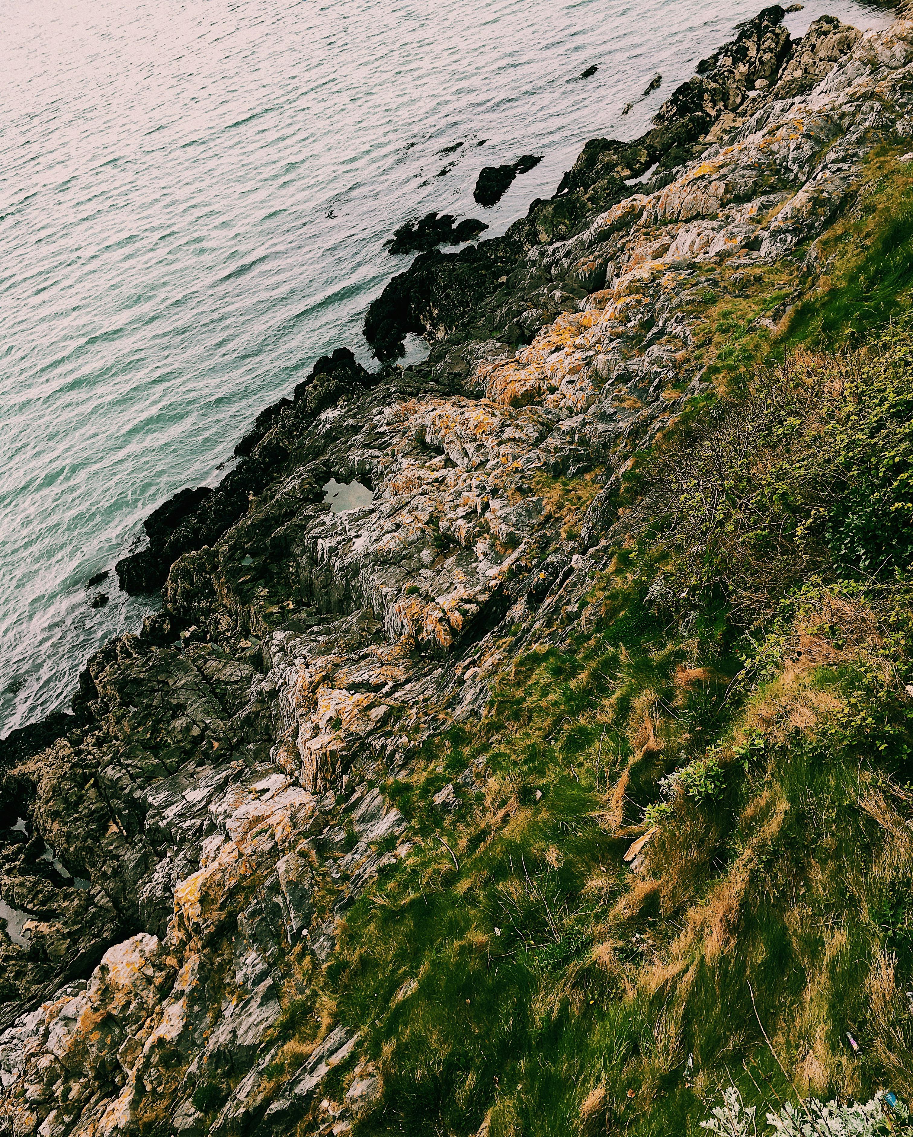 Stone cliff on sandy beach near ocean · Free Stock Photo