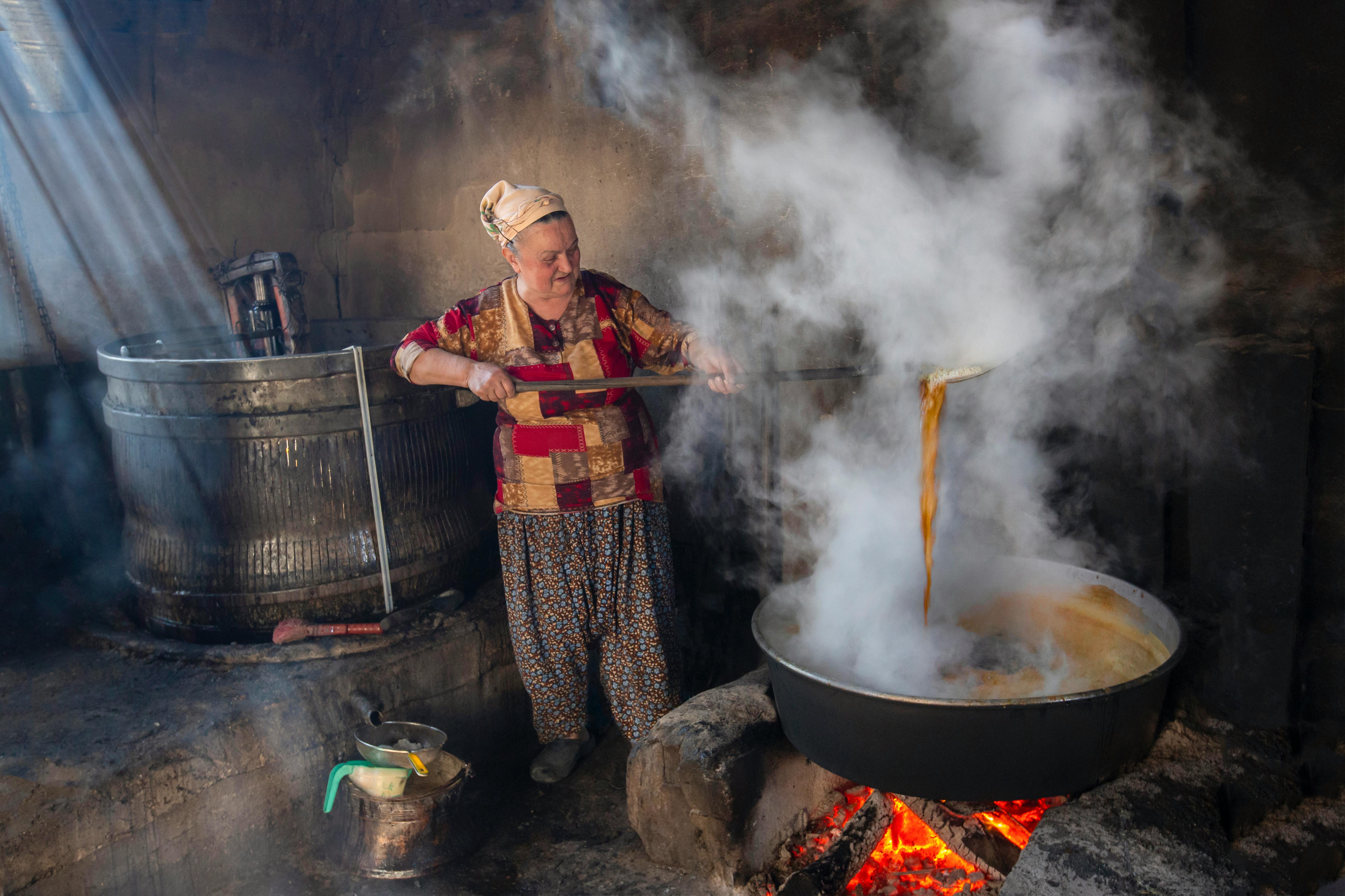 A Woman Cooking with a Large Pot · Free Stock Photo