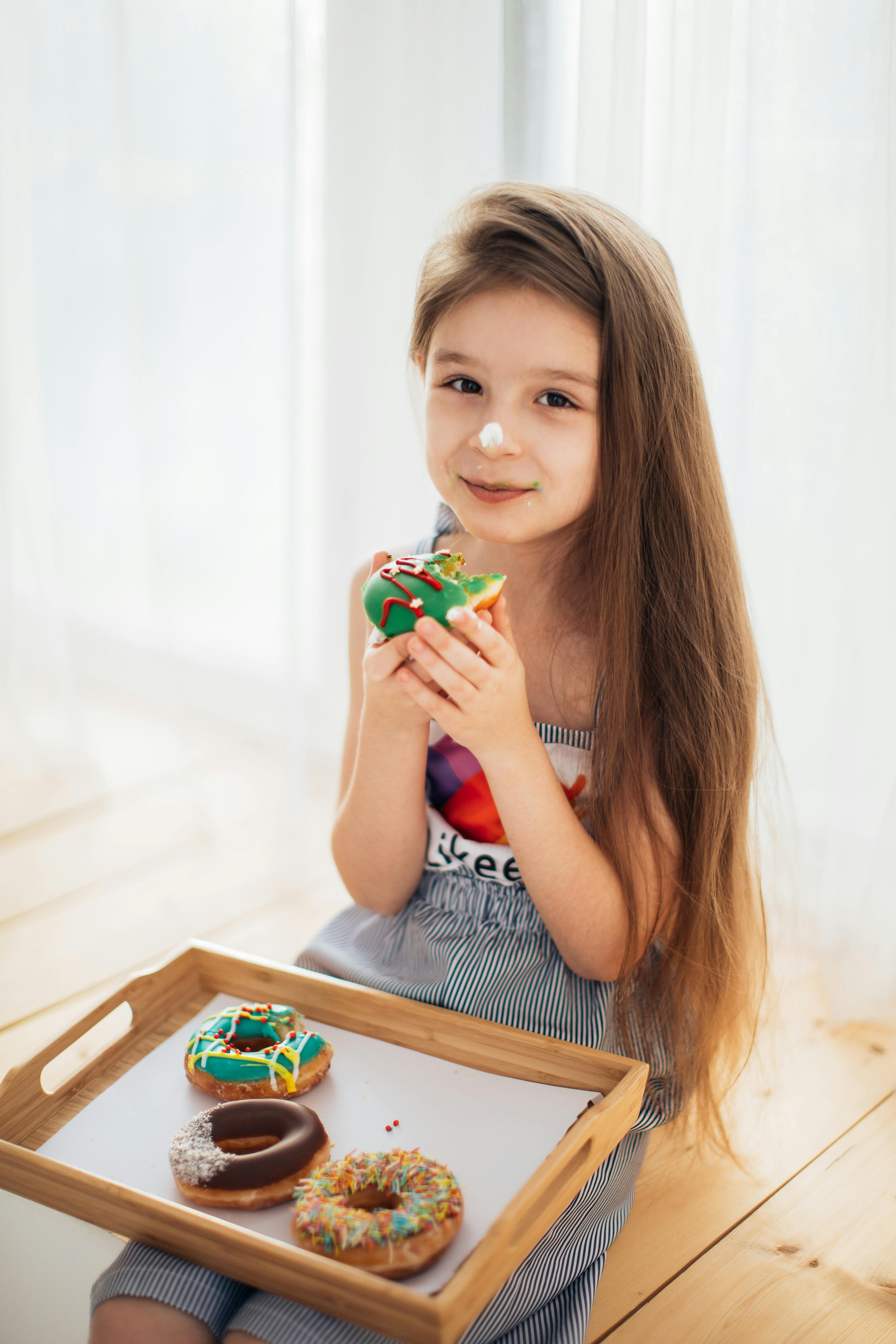 Photo of a Girl Eating a Green Donut · Free Stock Photo