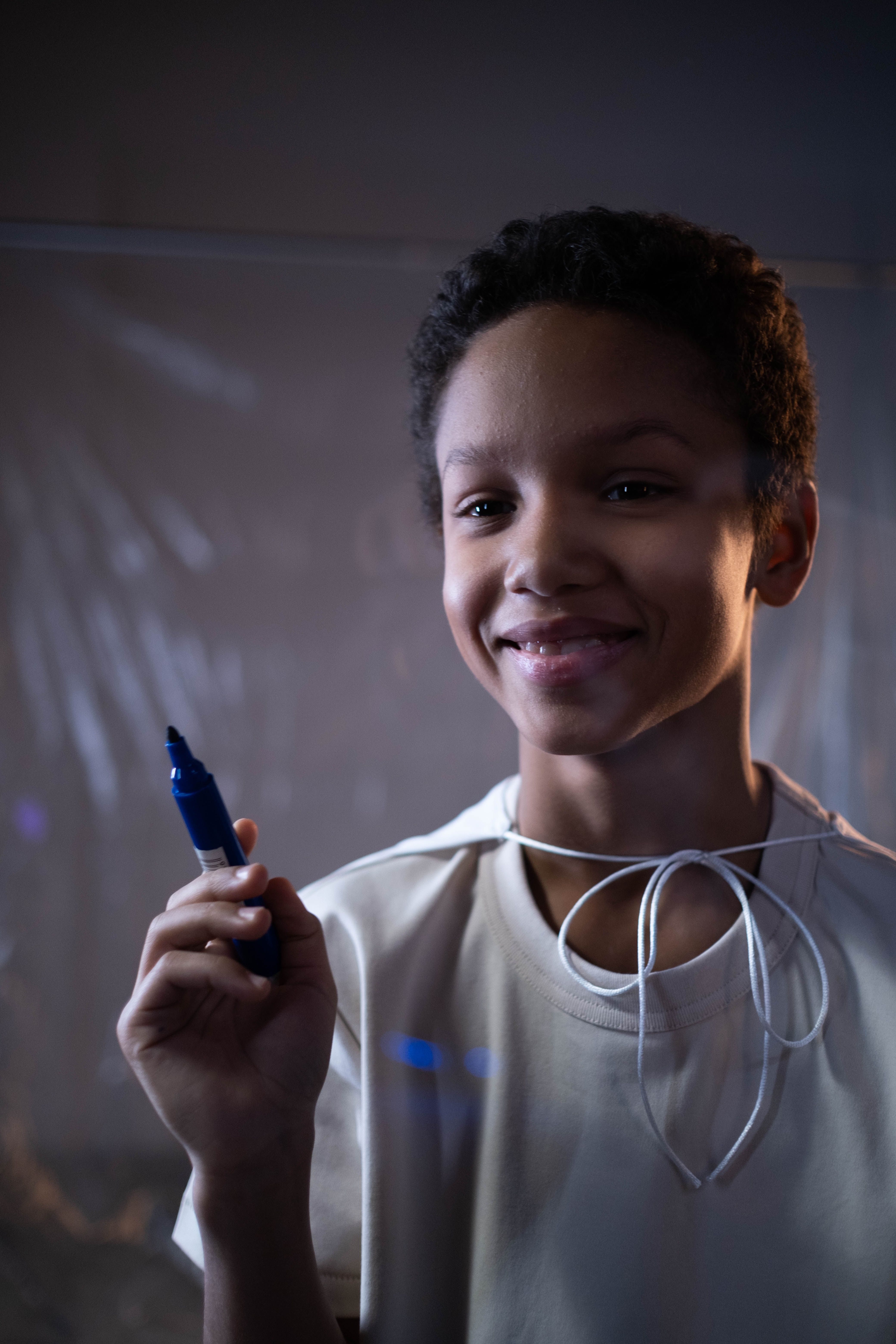 A Boy in White Shirt Holding a Marker Pen · Free Stock Photo