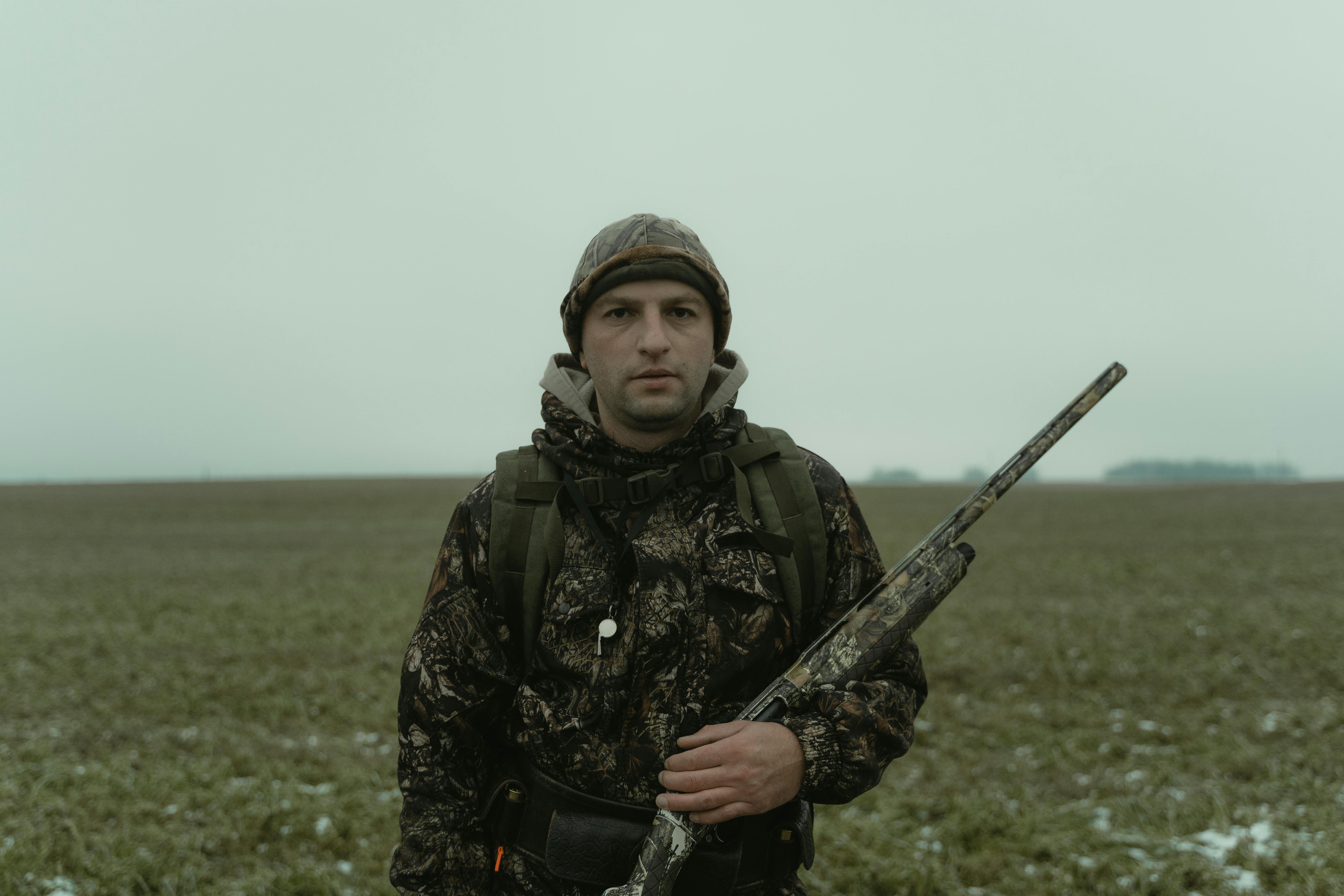 A Man Carrying a Rifle · Free Stock Photo