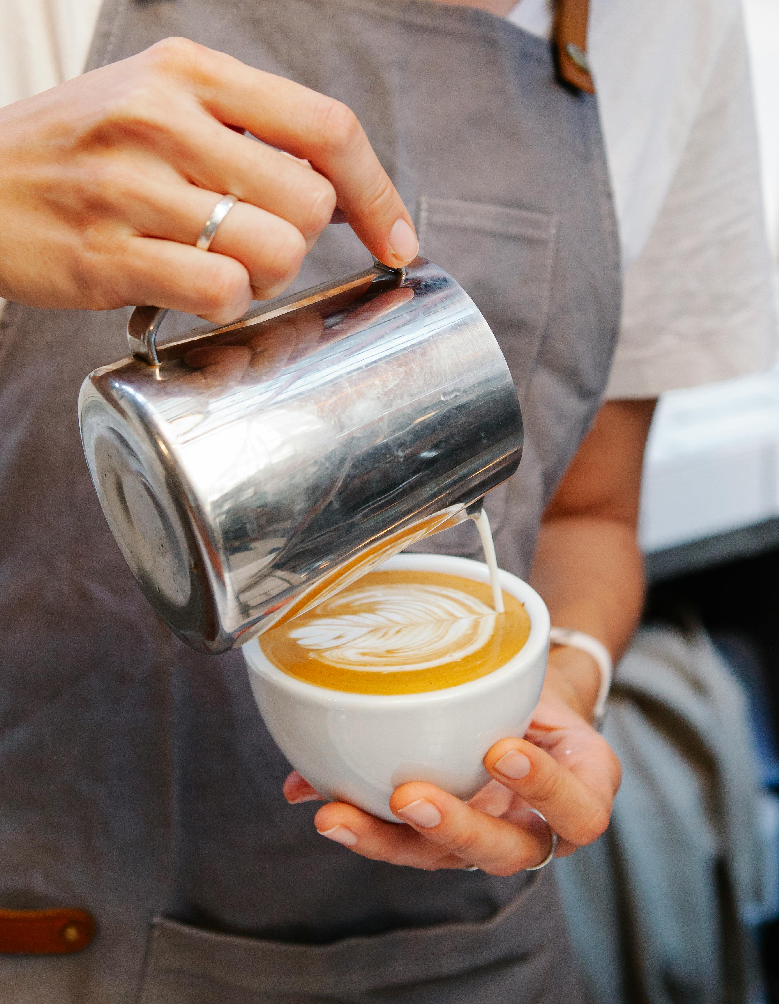 Woman making latte art in coffee · Free Stock Photo