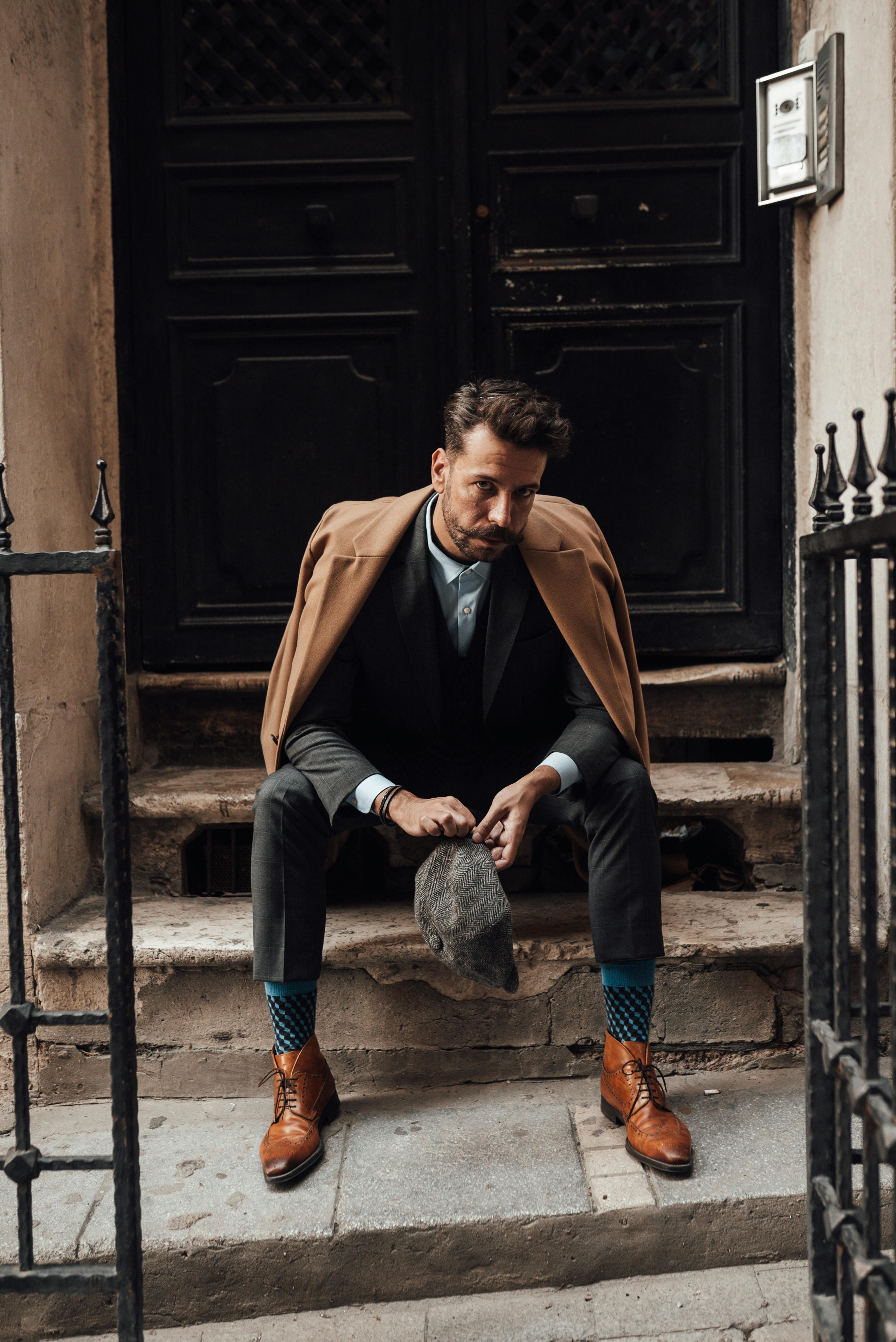 Confident man in stylish clothes sitting on stairs against door · Free ...