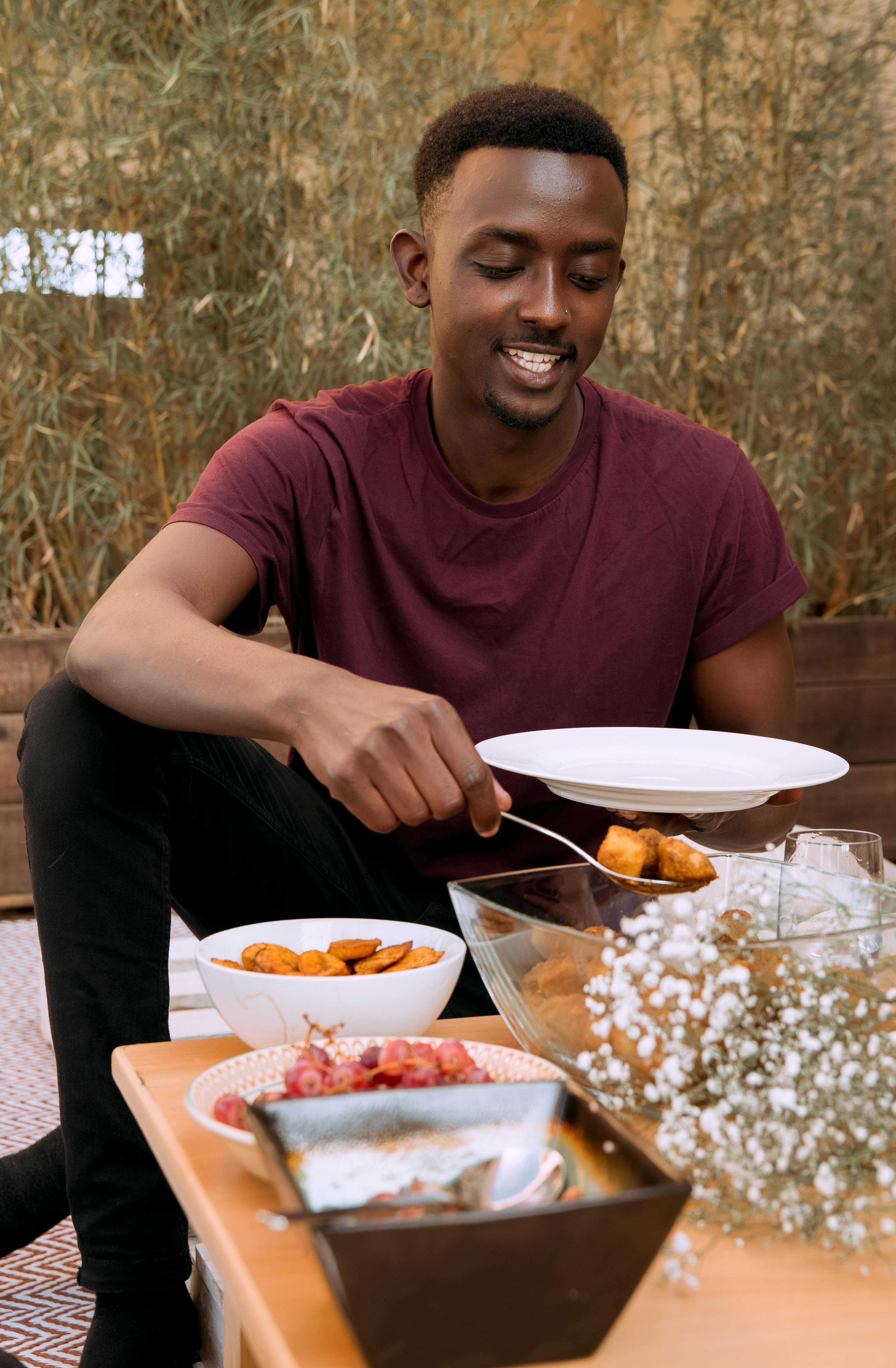 Man Putting Food on His Plate and Smiling · Free Stock Photo