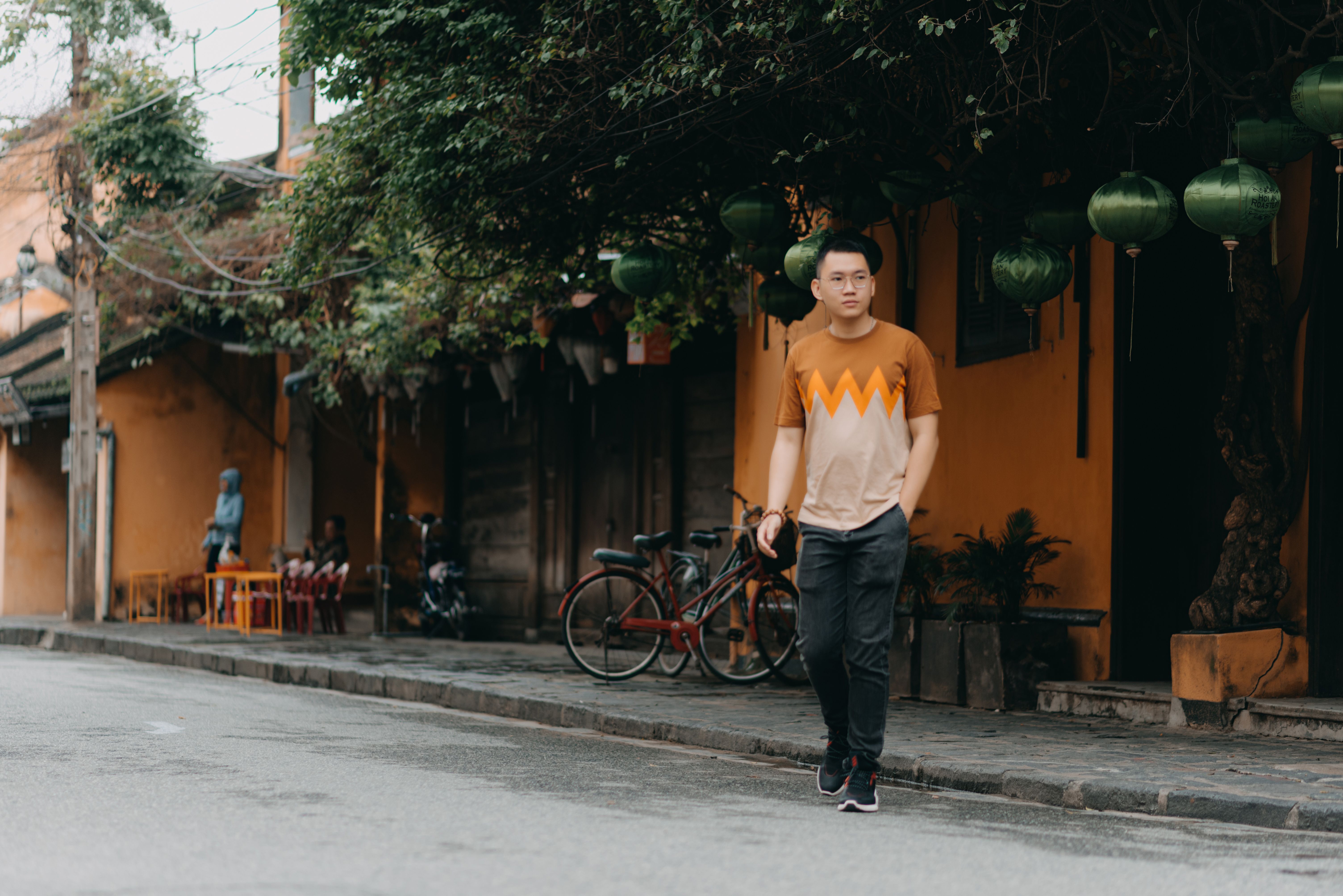 Focused ethnic male crossing city street · Free Stock Photo
