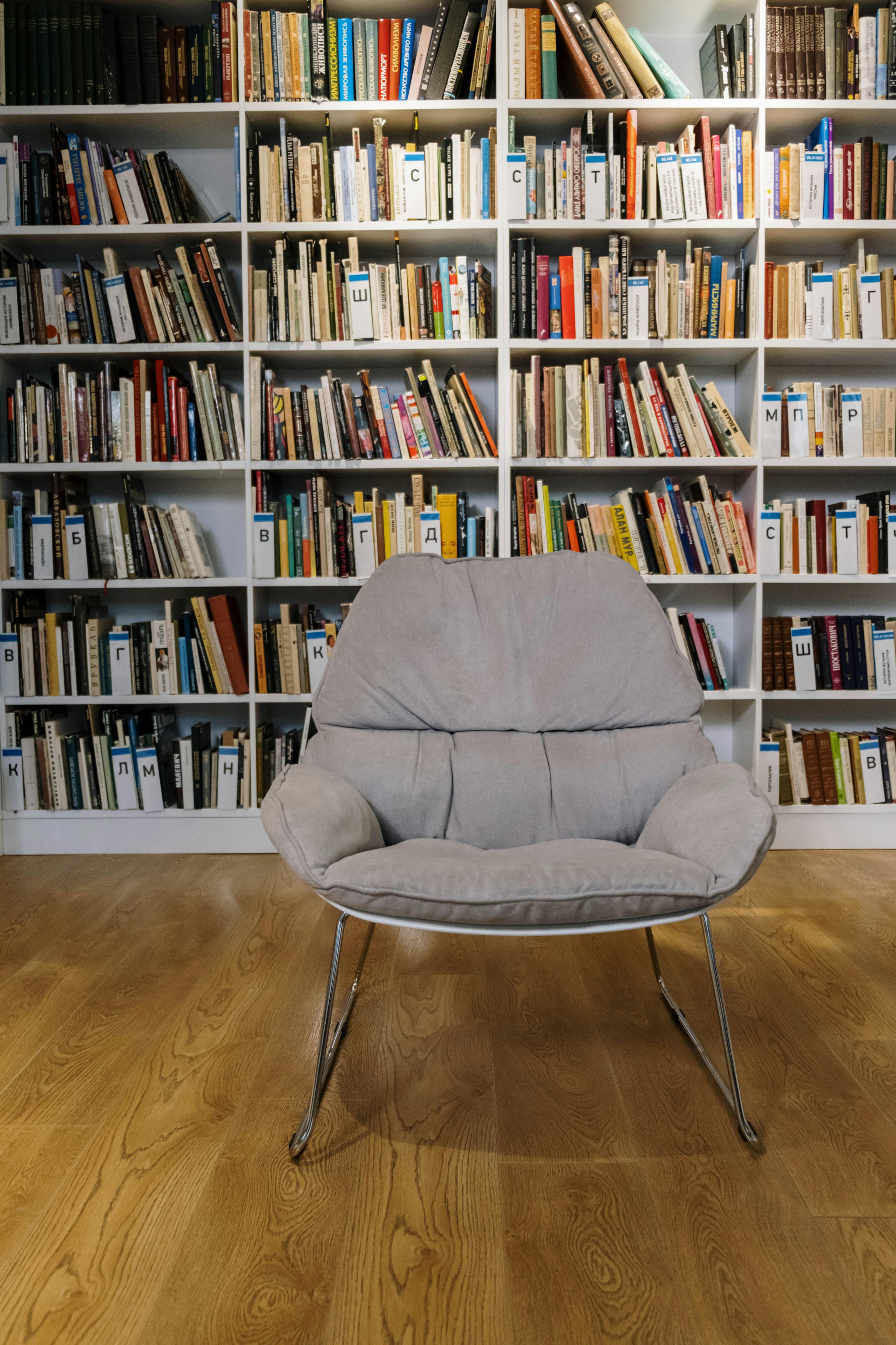 A Gray Padded Chair in the Library · Free Stock Photo
