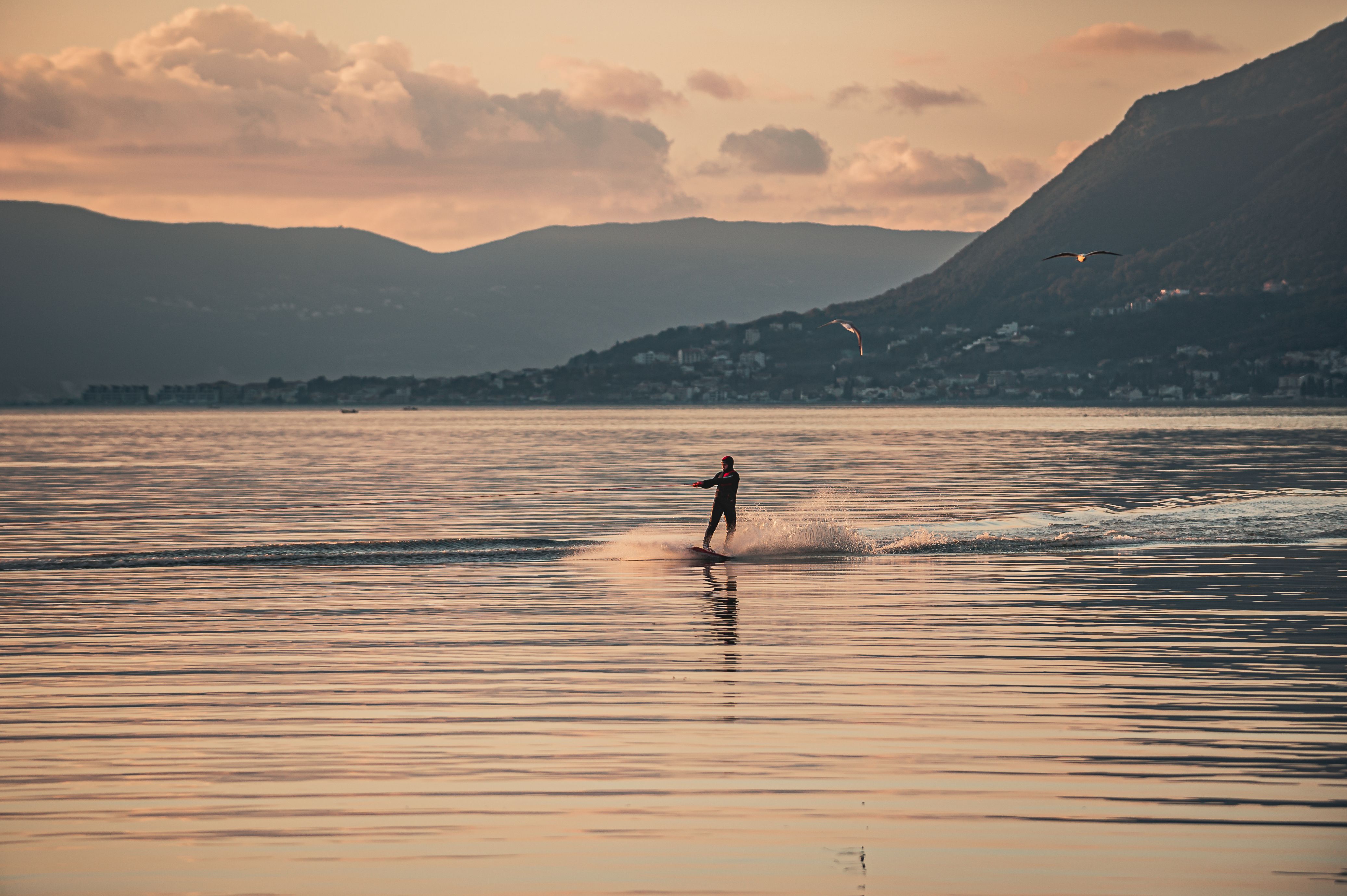 A Person Surfing on the Sea during Sunset · Free Stock Photo
