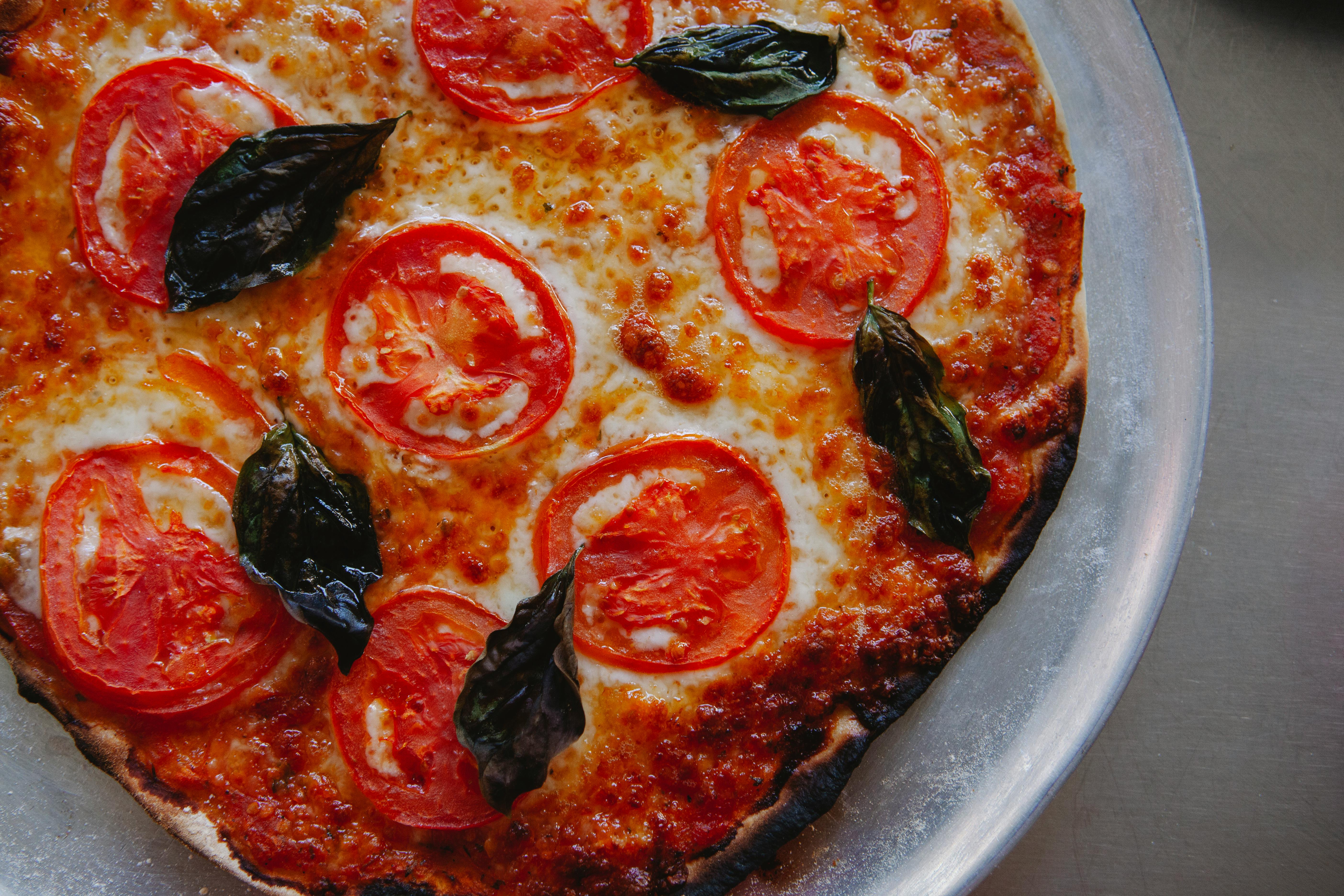 Close-up of a Pizza with Tomatoes and Basil · Free Stock Photo