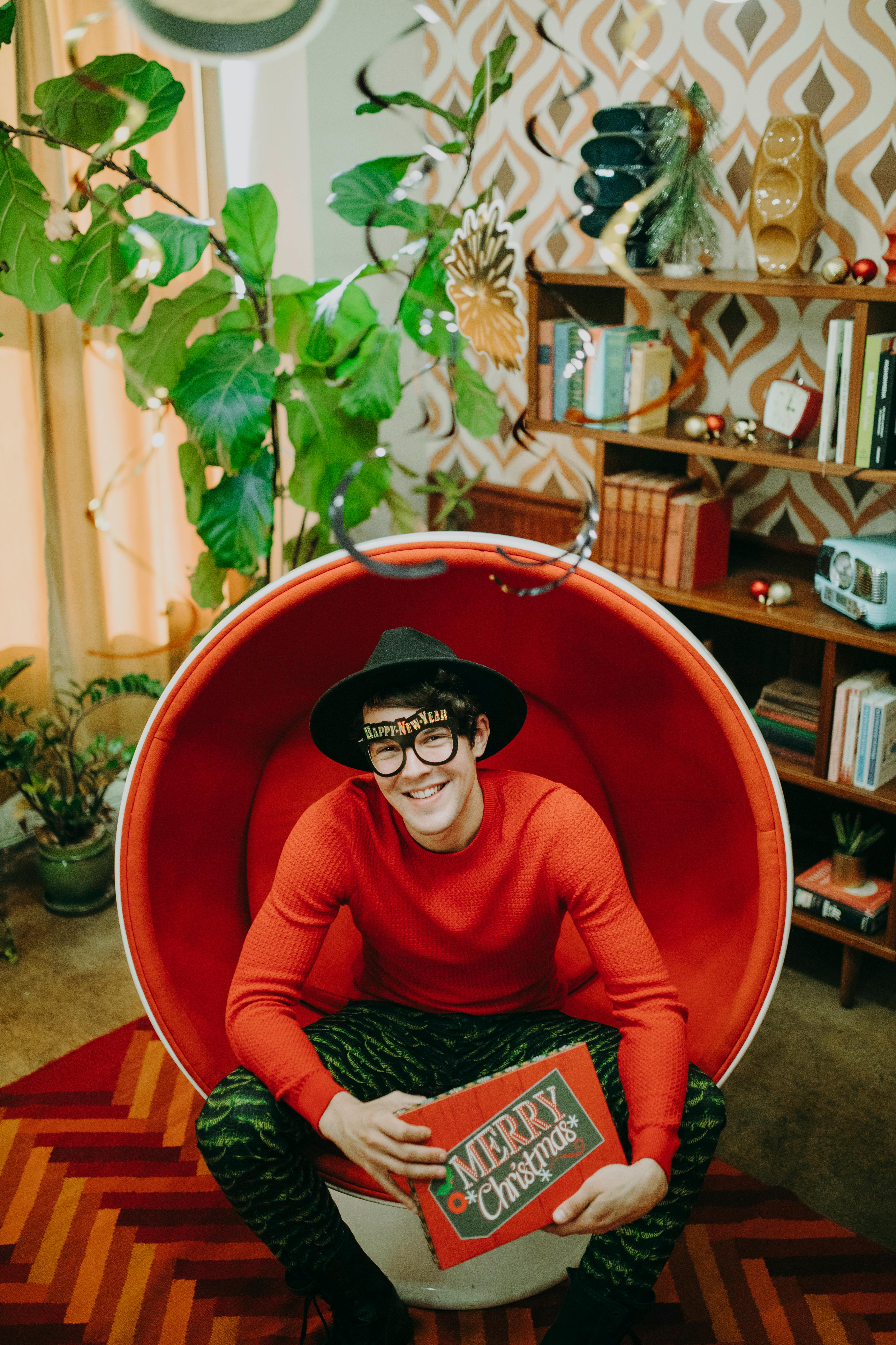 A Man in Red Sweater Sitting on Red Chair · Free Stock Photo