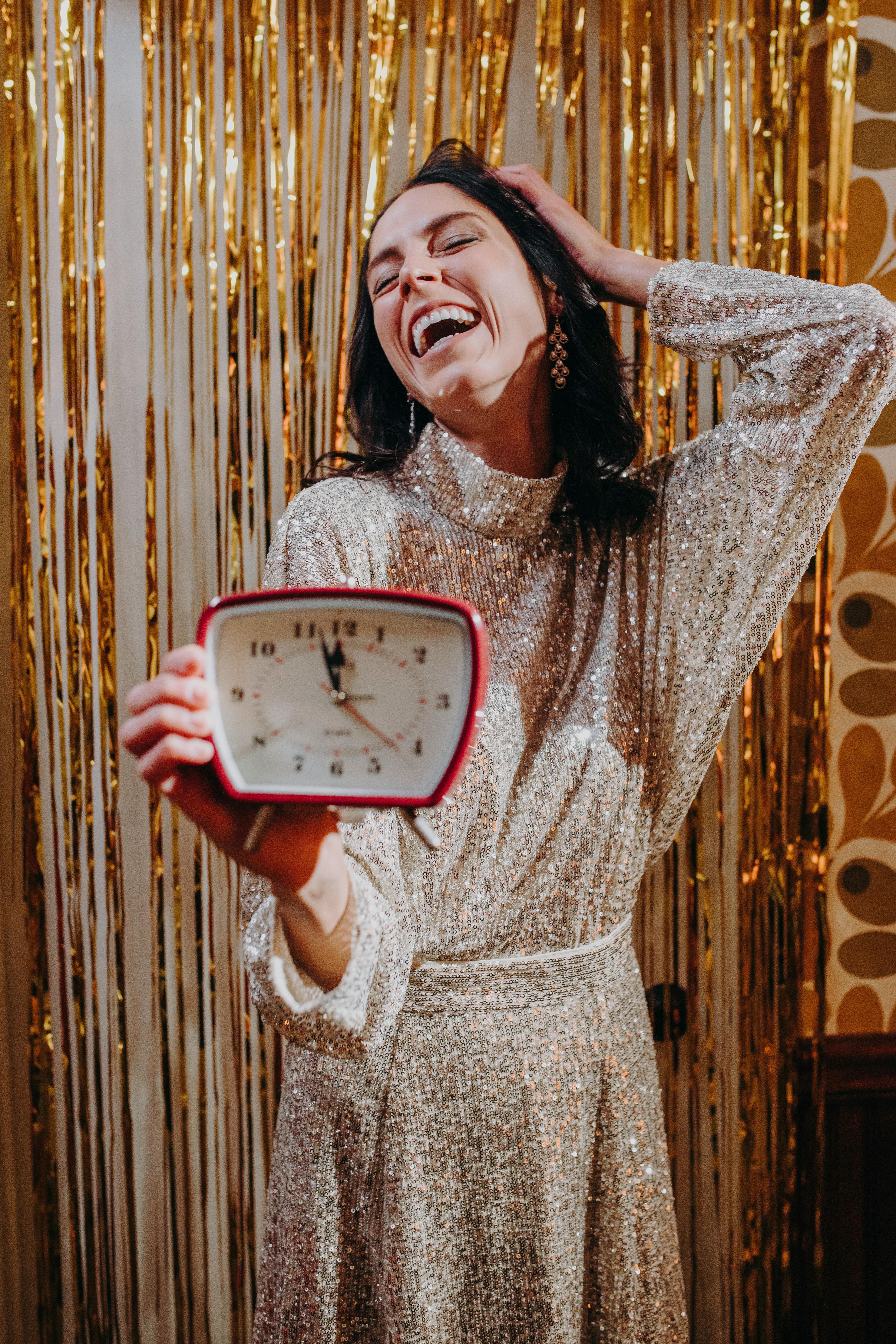 Woman Laughing While Holding an Alarm Clock · Free Stock Photo
