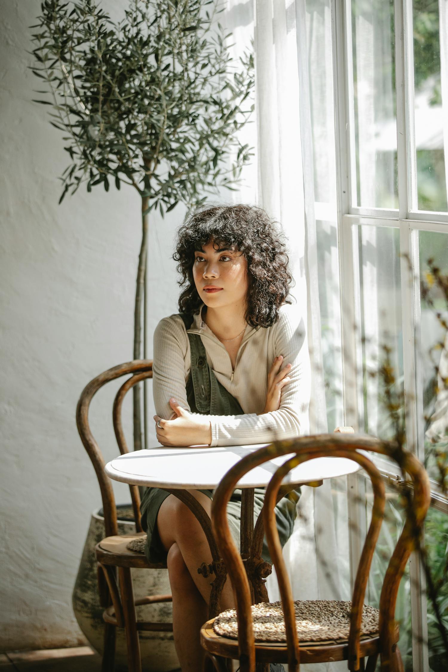 Charming woman sitting at table near window in cafe · Free Stock Photo Charming woman sitting at table near window in cafe · Free Stock Photo