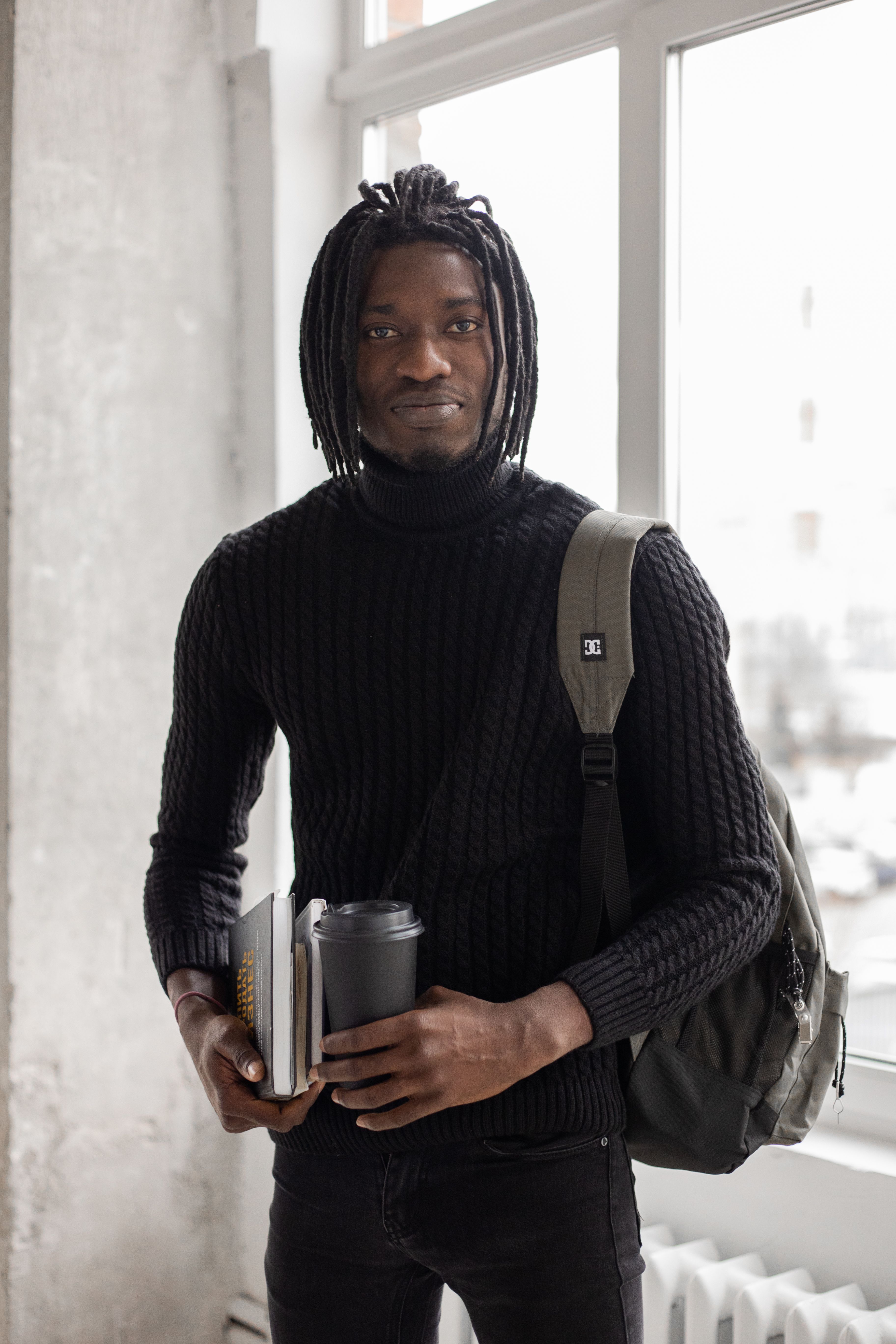 Black man with backpack and books in room · Free Stock Photo