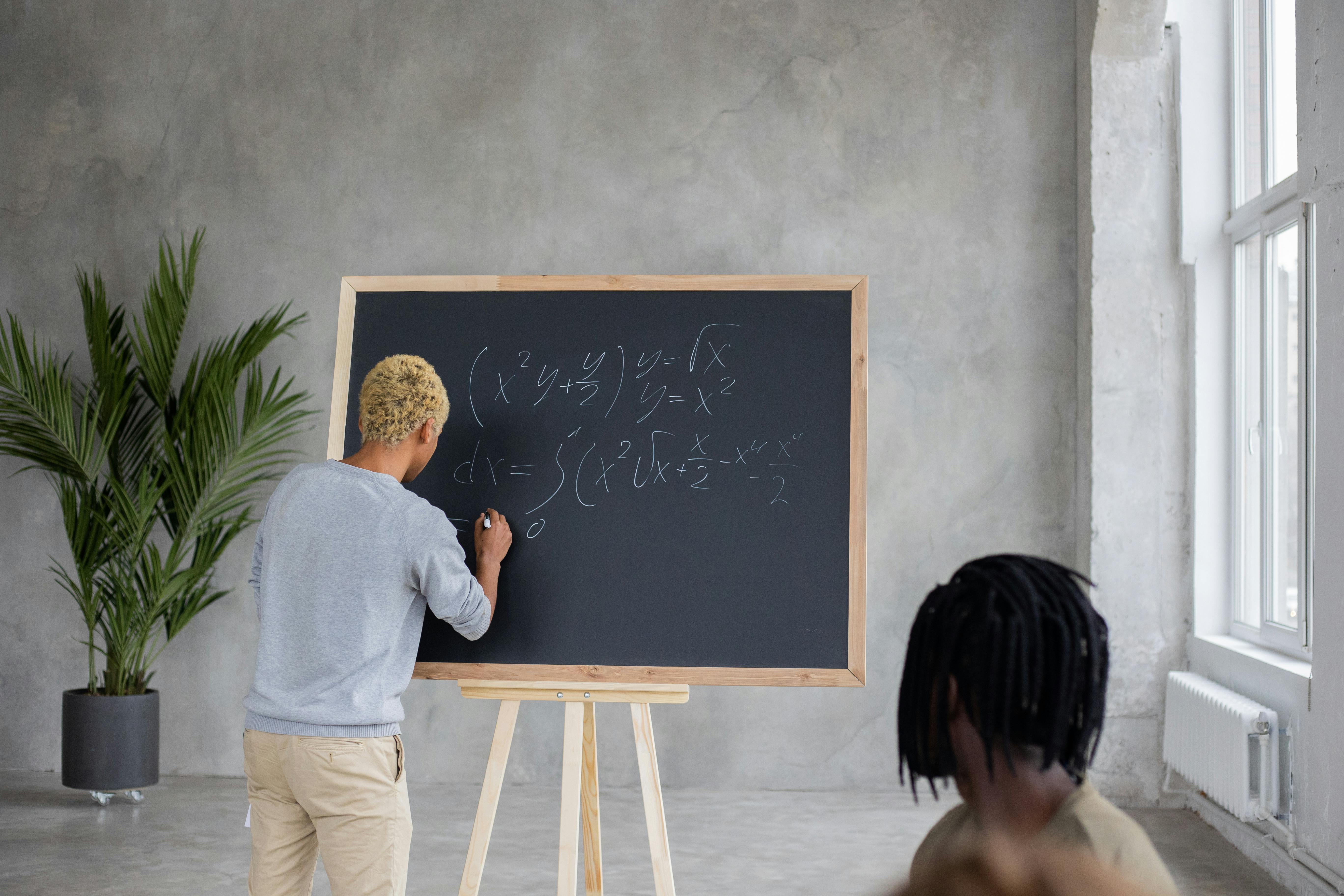 Concentrated black kid doing sums · Free Stock Photo