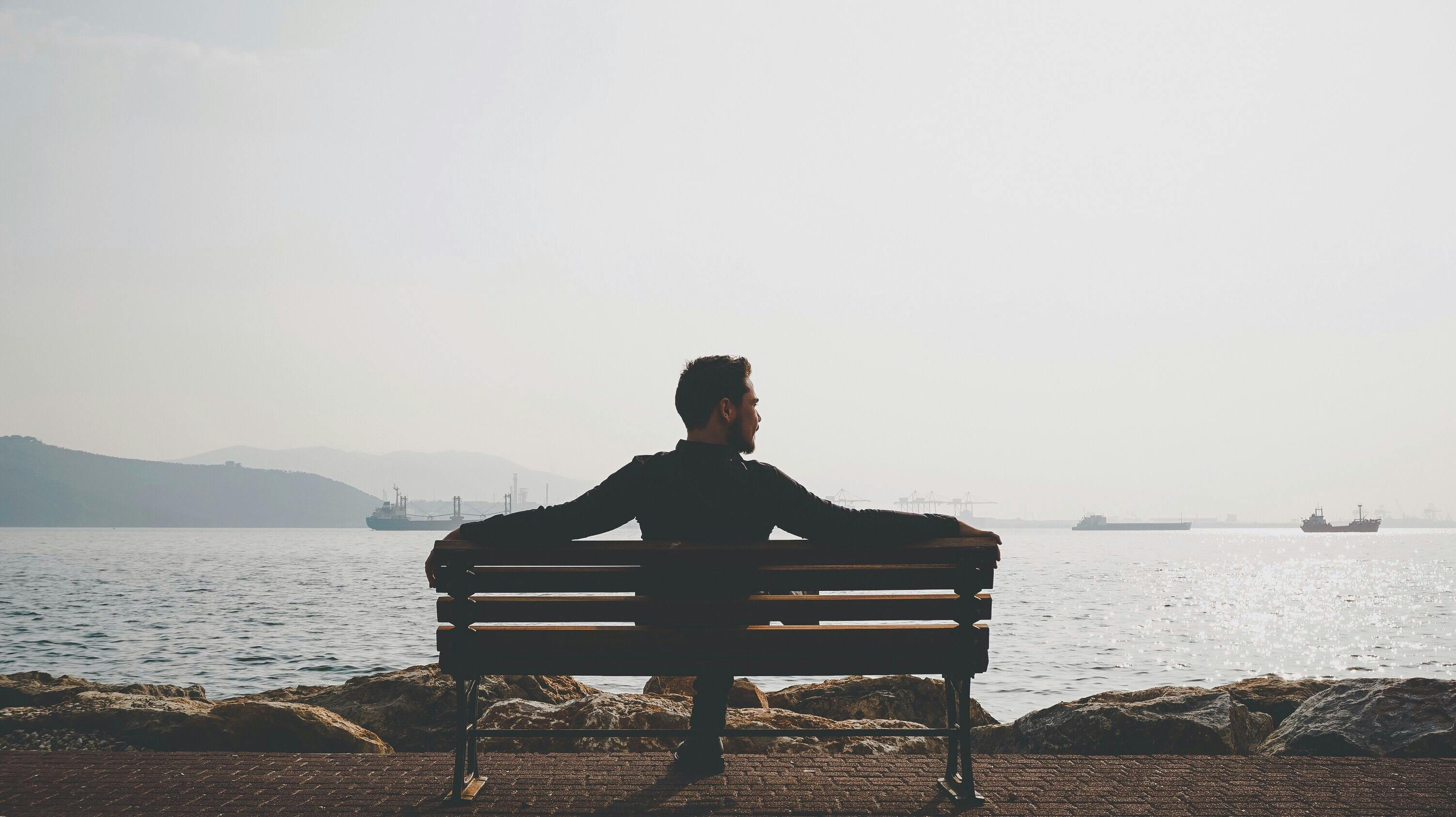 Photo of Man Sitting on Dock · Free Stock Photo