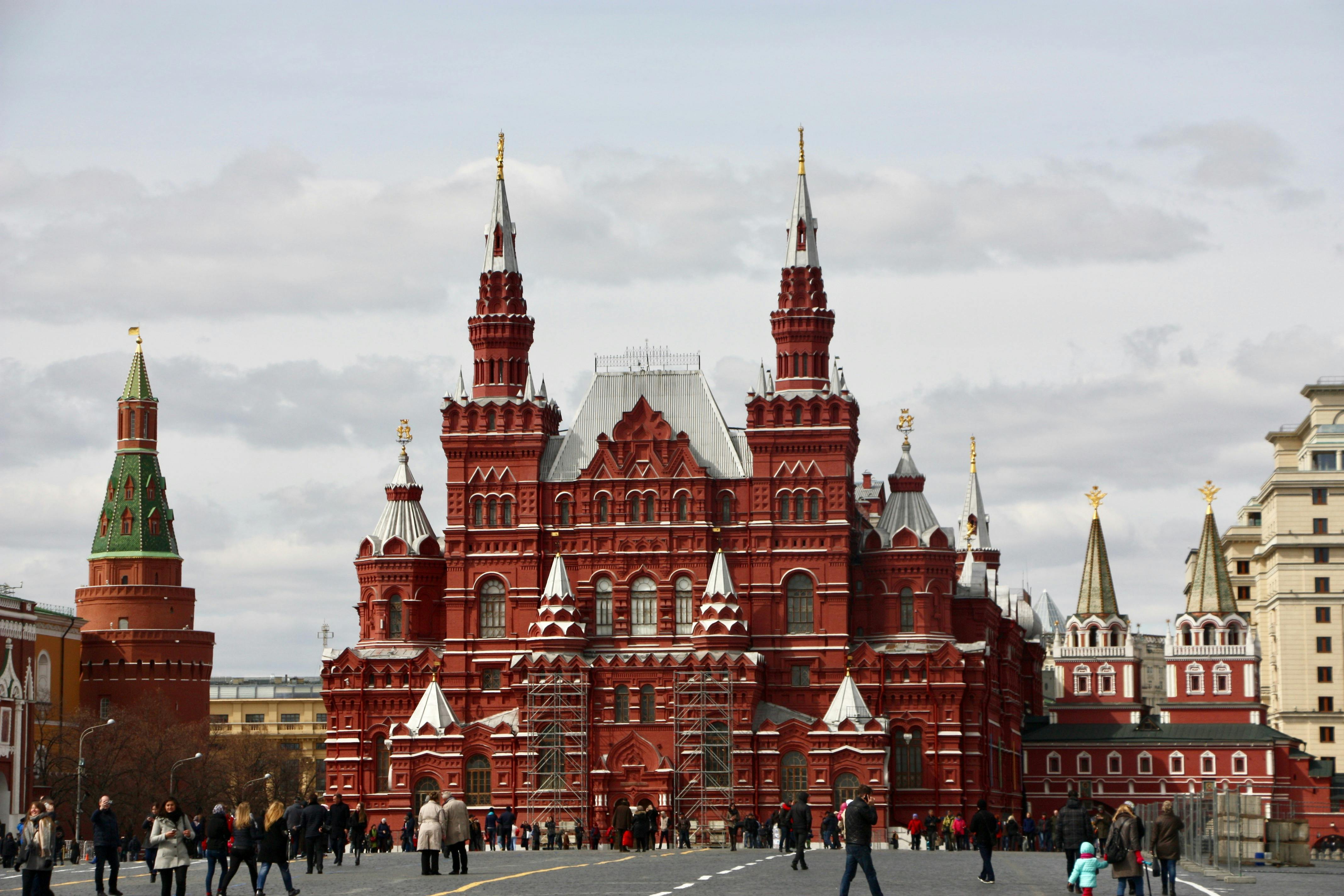 Photo of People Walking Near the Red Square Building · Free Stock Photo
