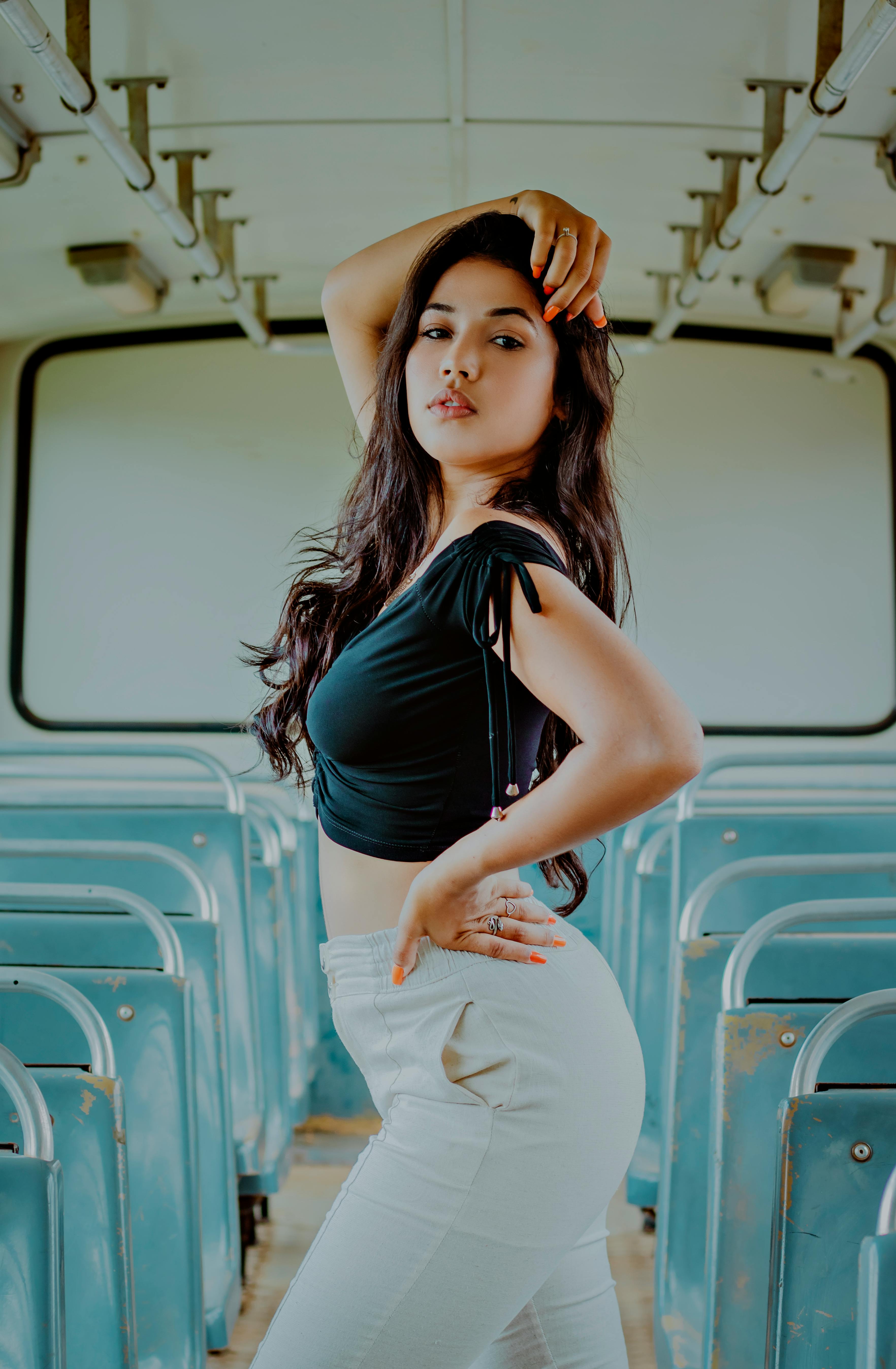 Woman Posing in Bus Aisle Between Empty Seats · Free Stock Photo
