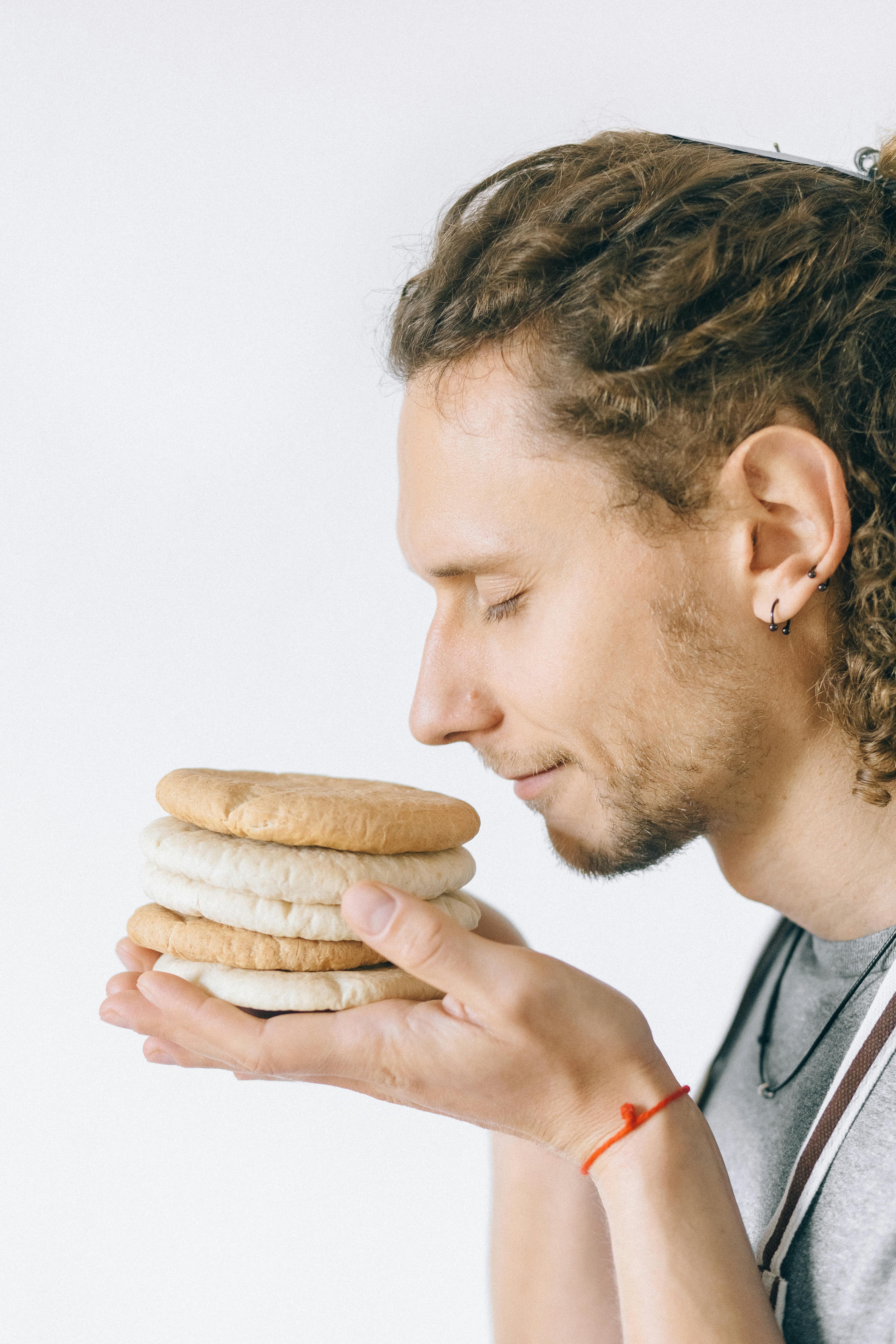 Side View of a Man Smelling Bread · Free Stock Photo