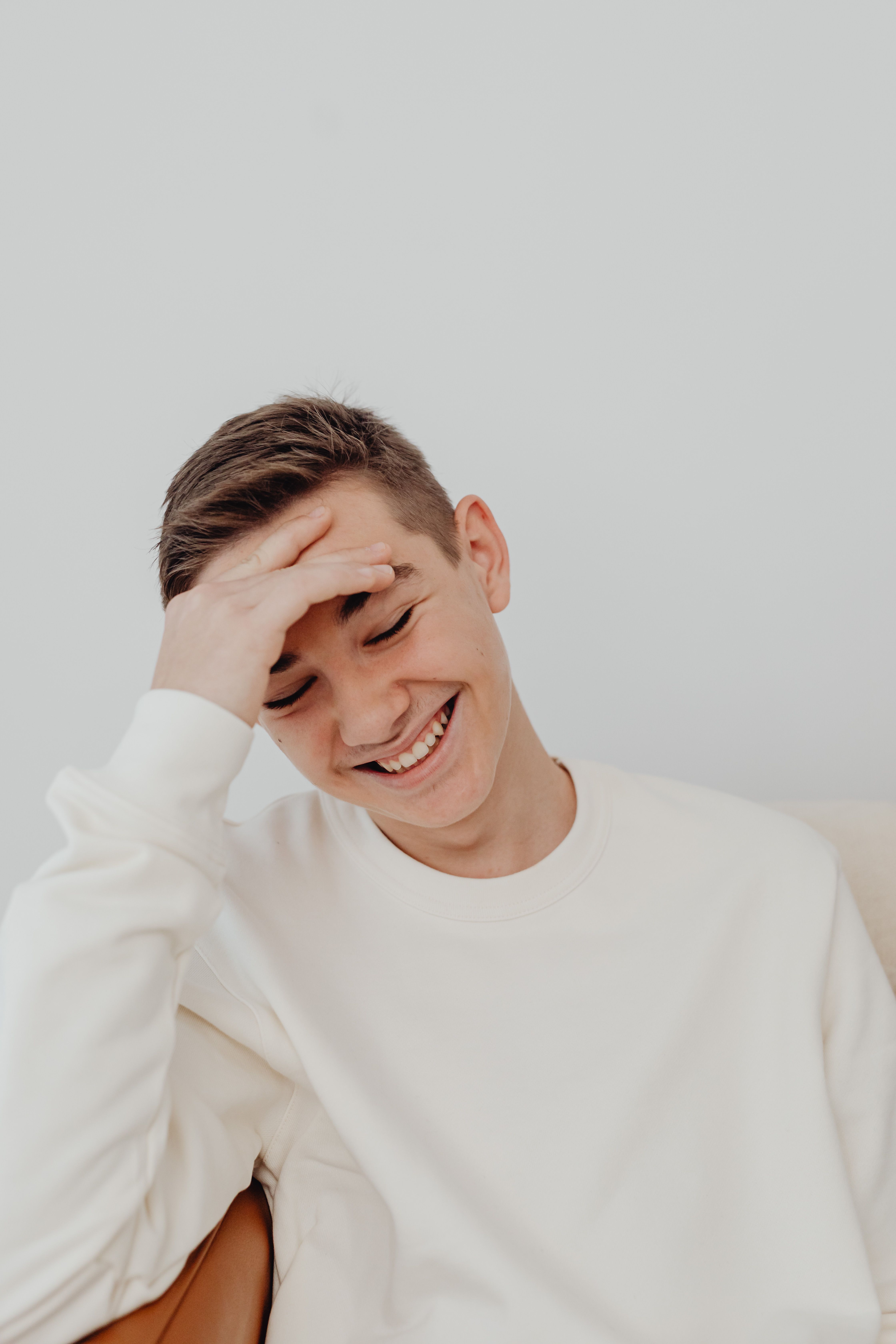Smiling Man with Hand on Forehead · Free Stock Photo