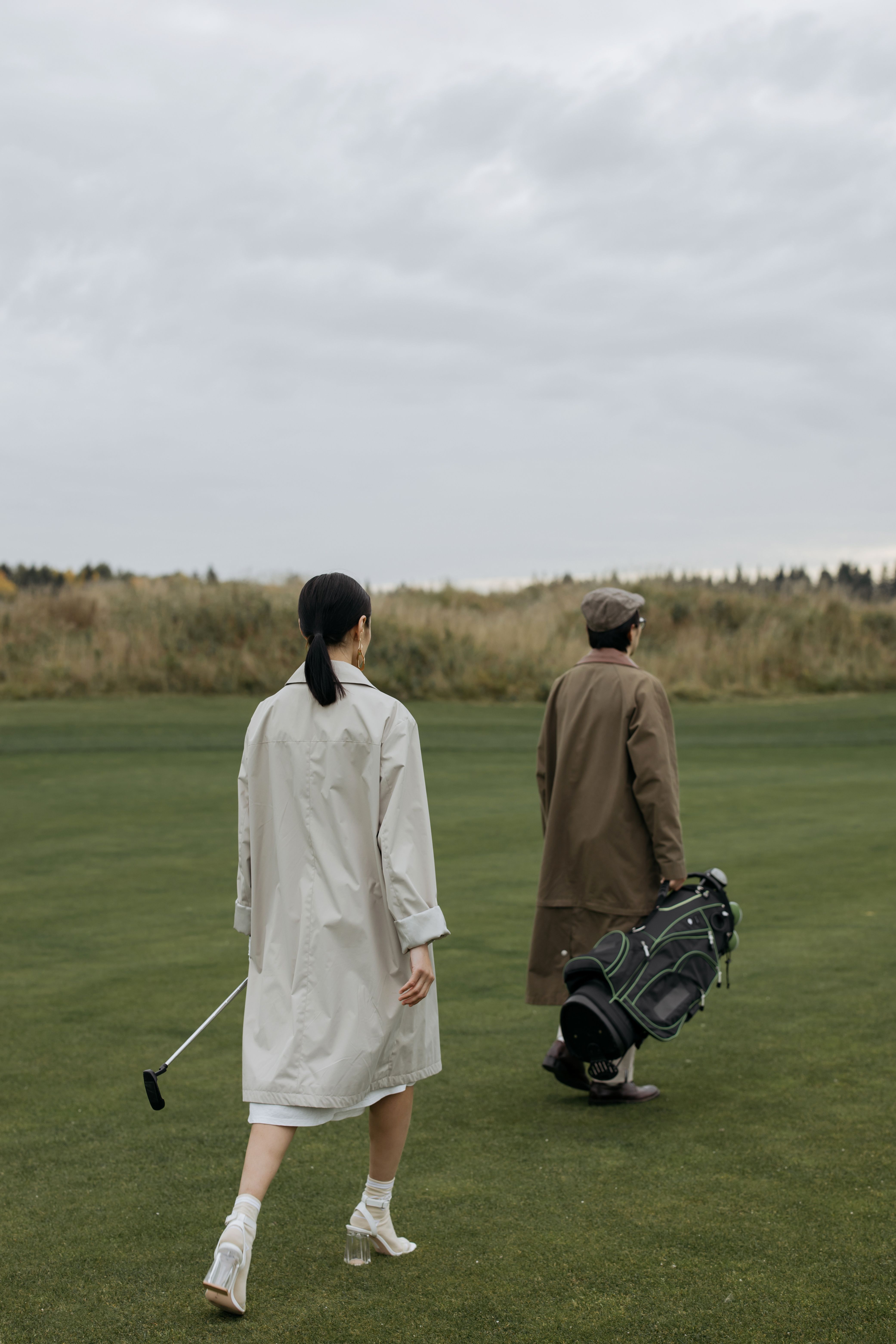 Elegant Golfers in Coats on Lawn · Free Stock Photo