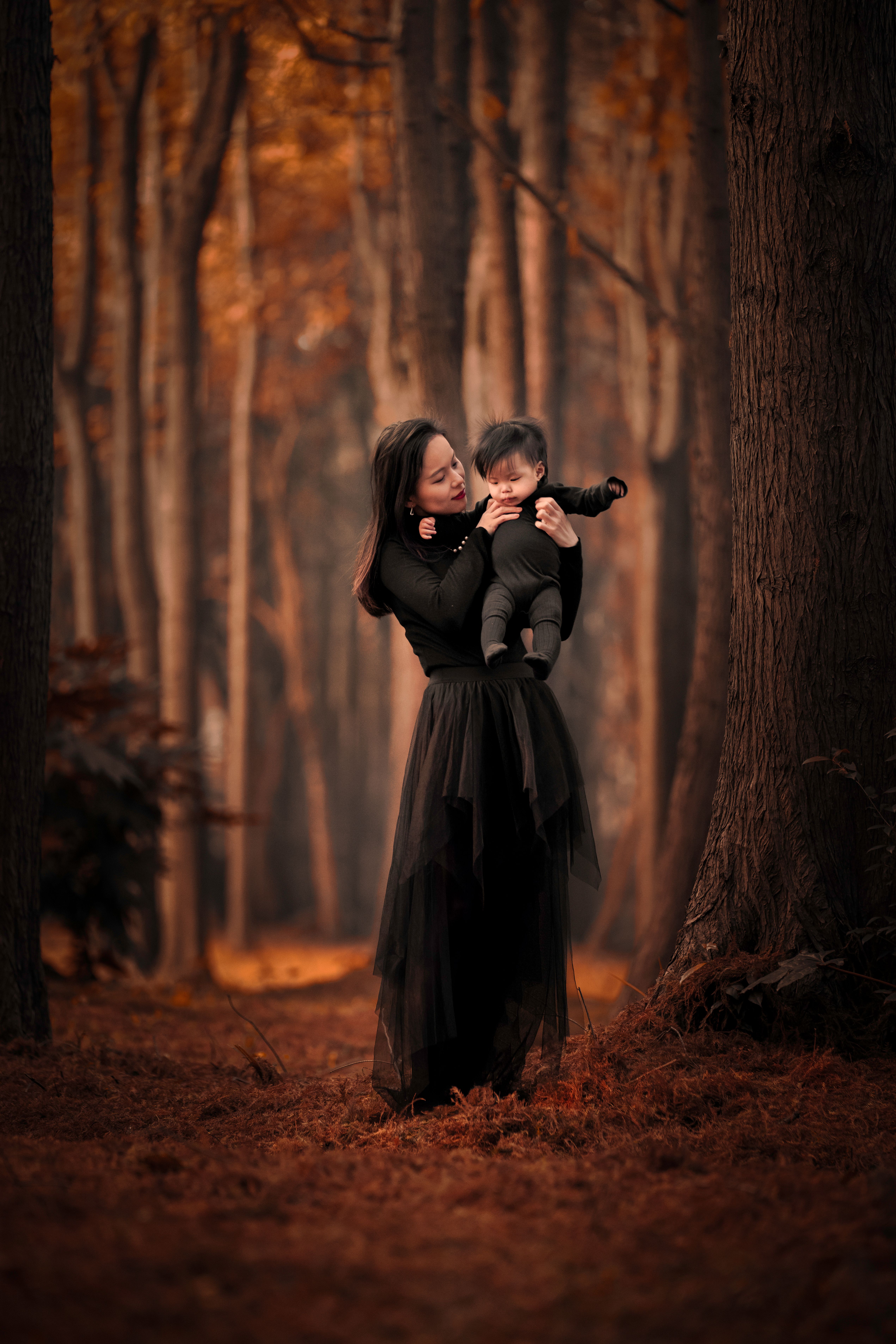 Woman Holding a Baby in a Forest · Free Stock Photo