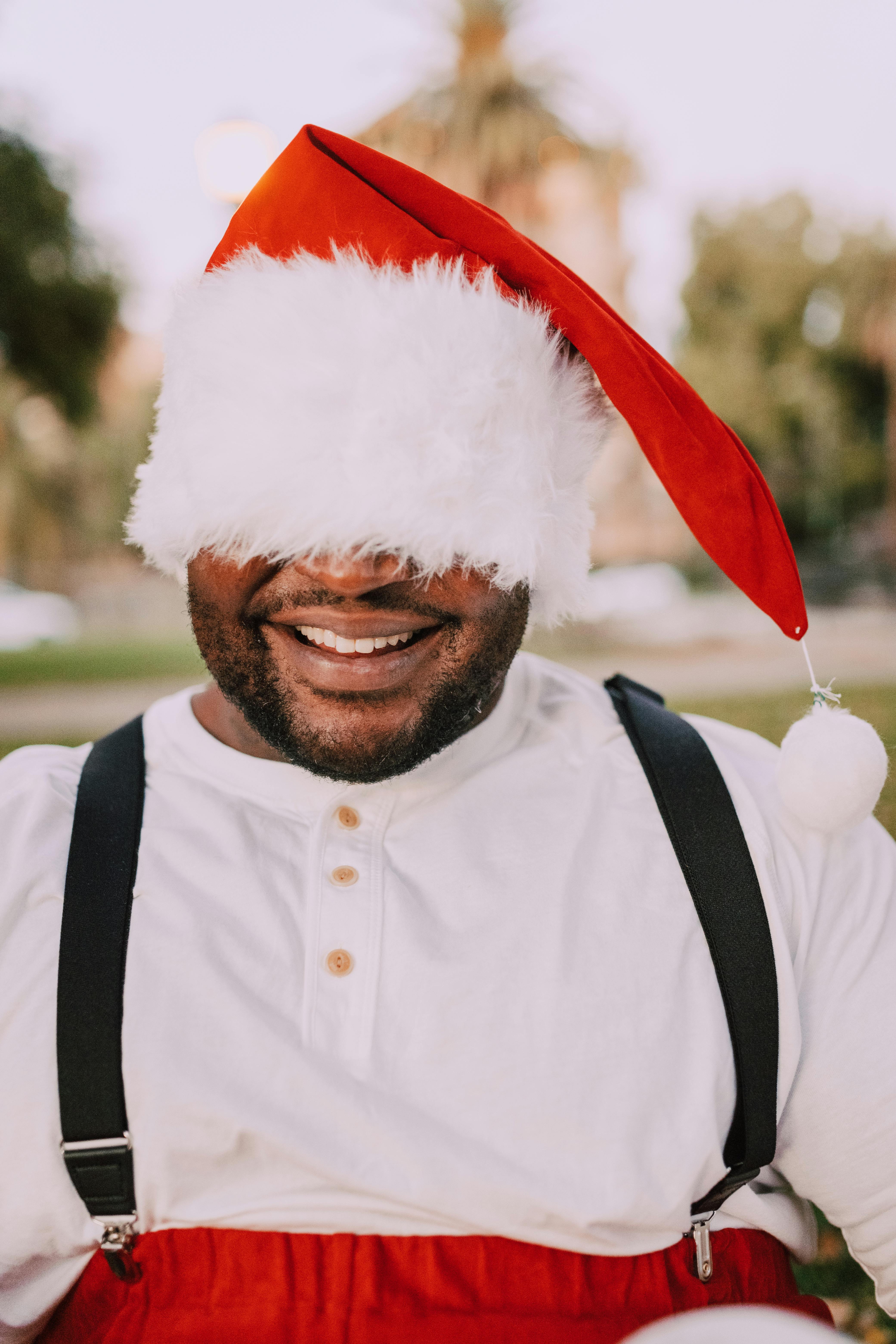 Man Wearing A Santa Hat Covering His Face · Free Stock Photo