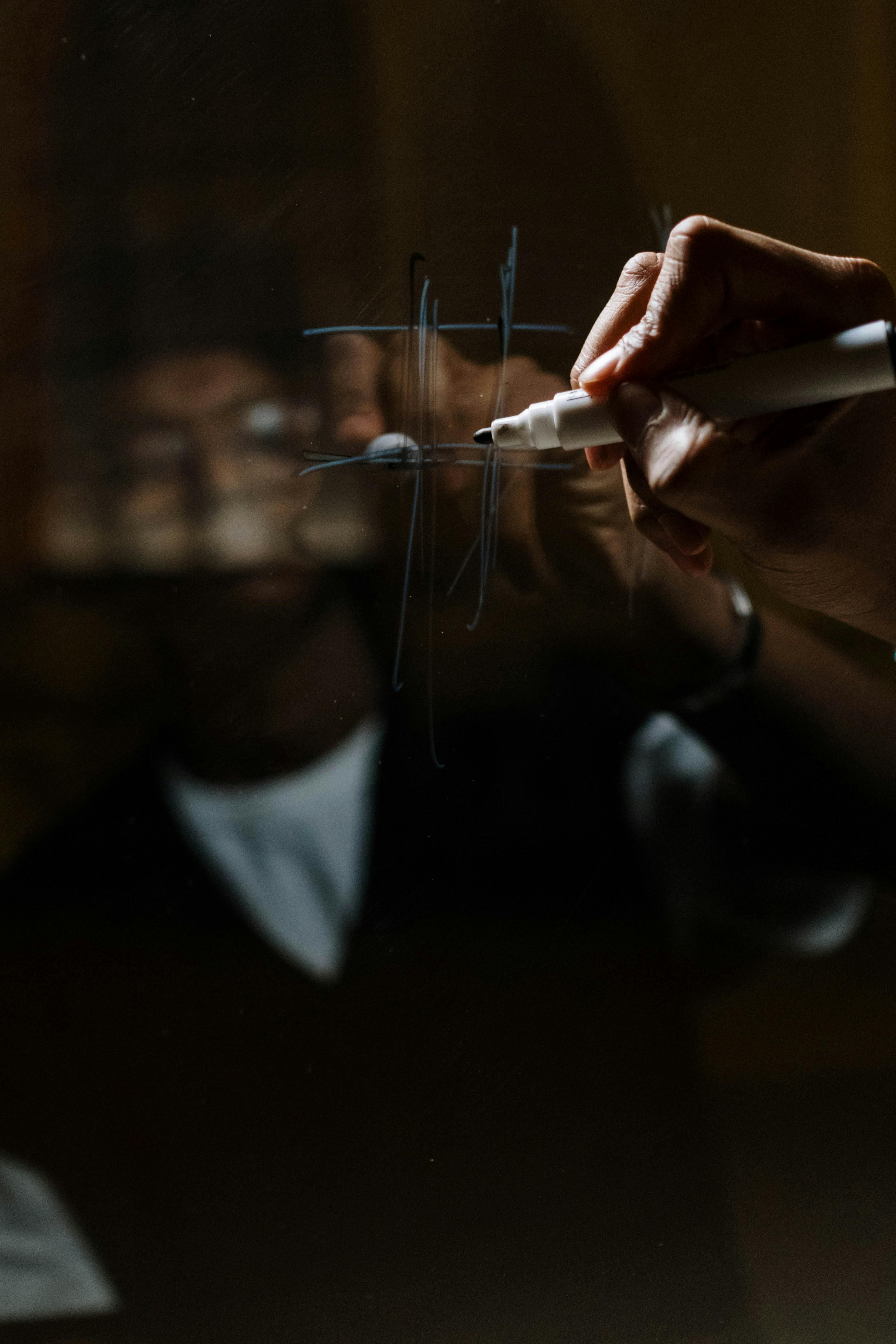 Person Using Black Marker Writing on Glass Board · Free Stock Photo