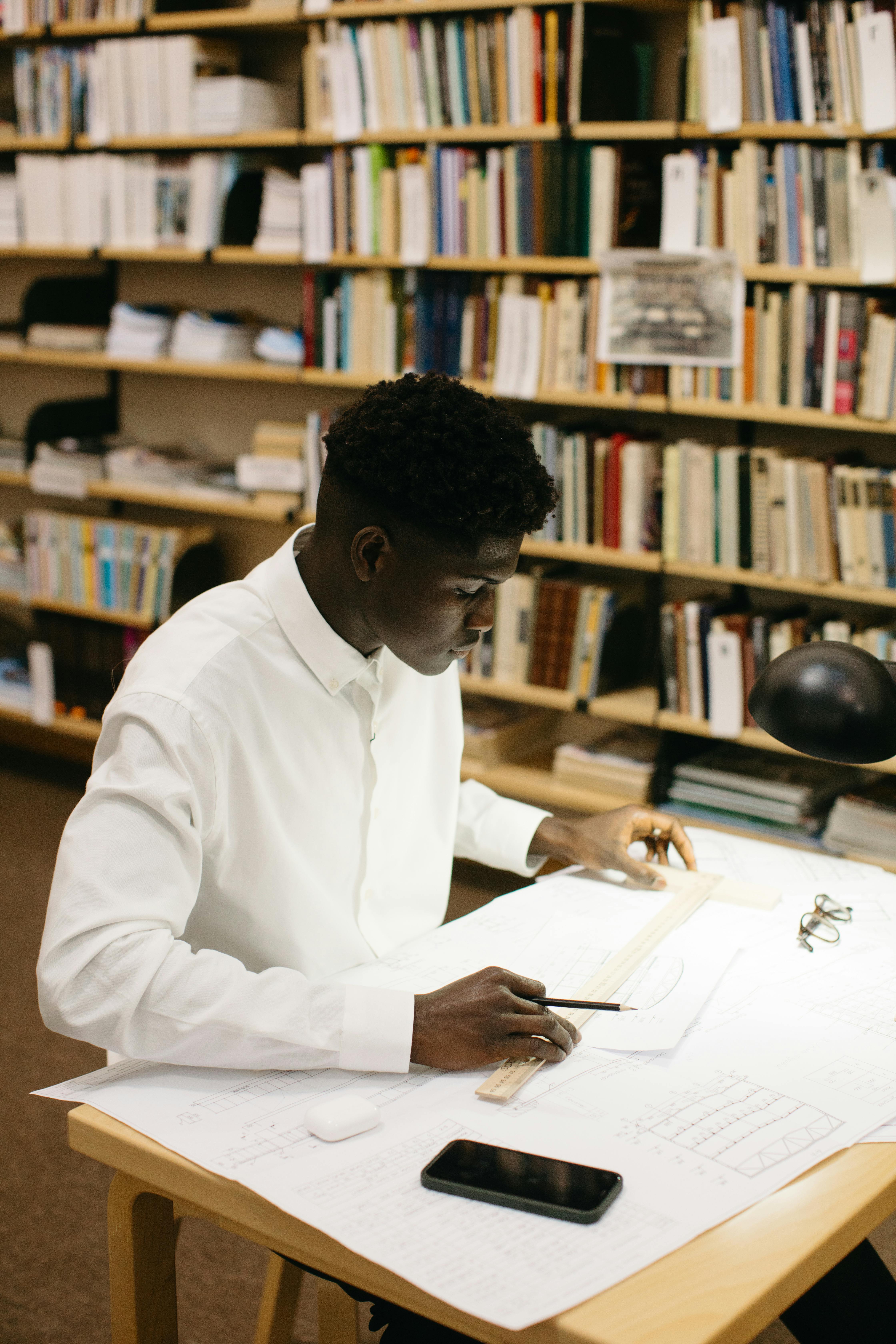 A Student Drafting a Design on a Paper · Free Stock Photo