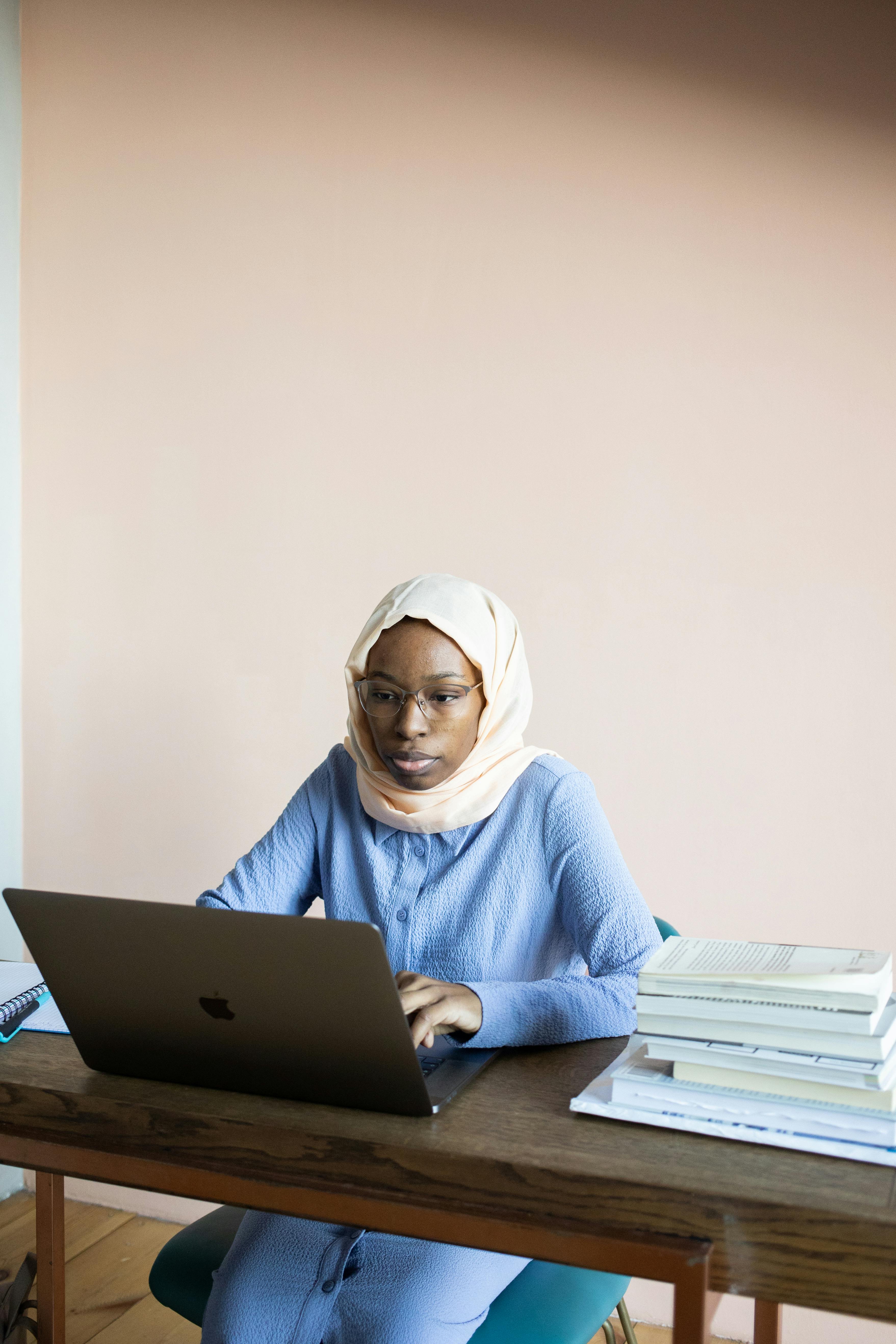 Serious student typing on laptop keyboard during studies · Free Stock Photo