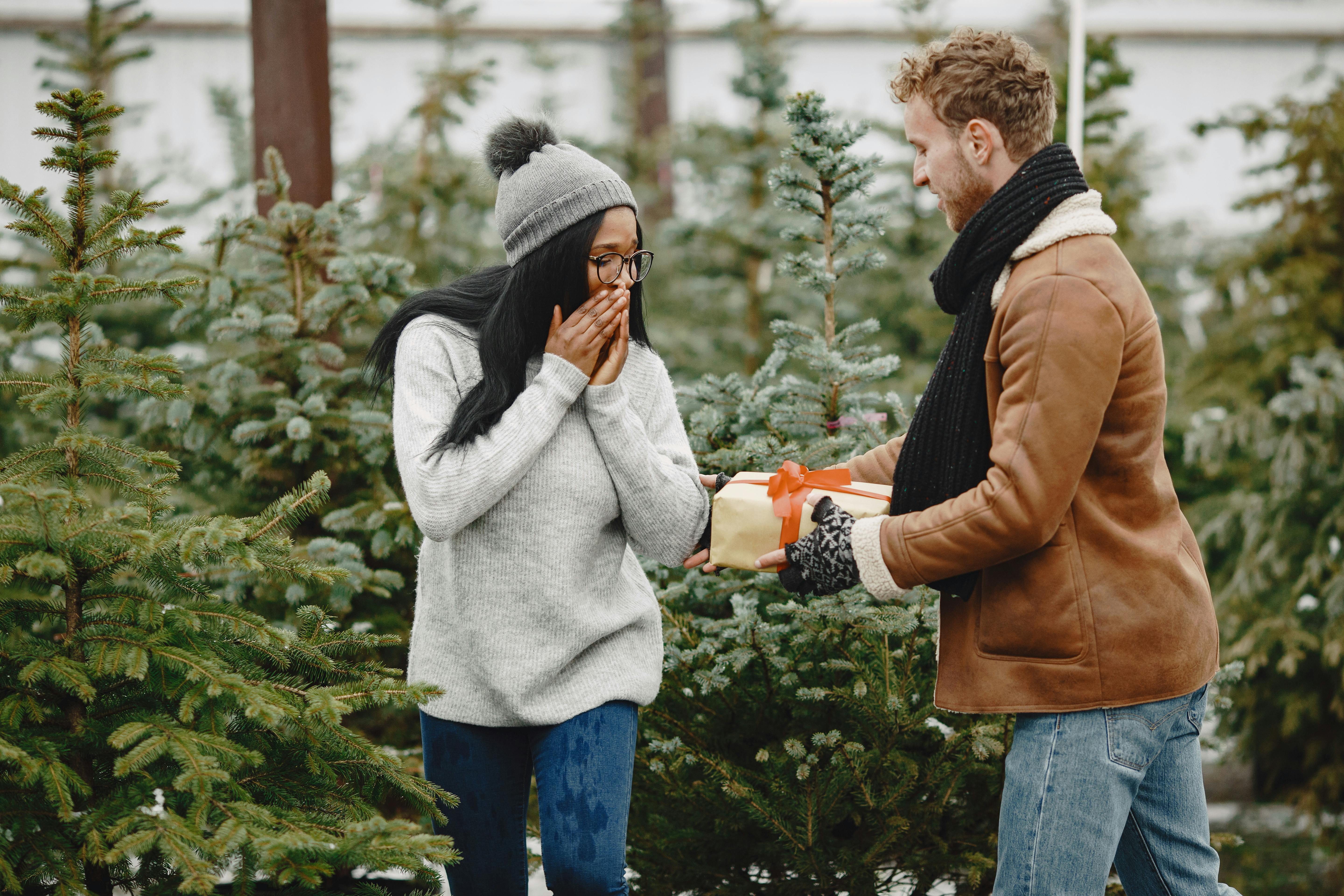 A Man Surprising His Woman With a Christmas Present · Free Stock Photo