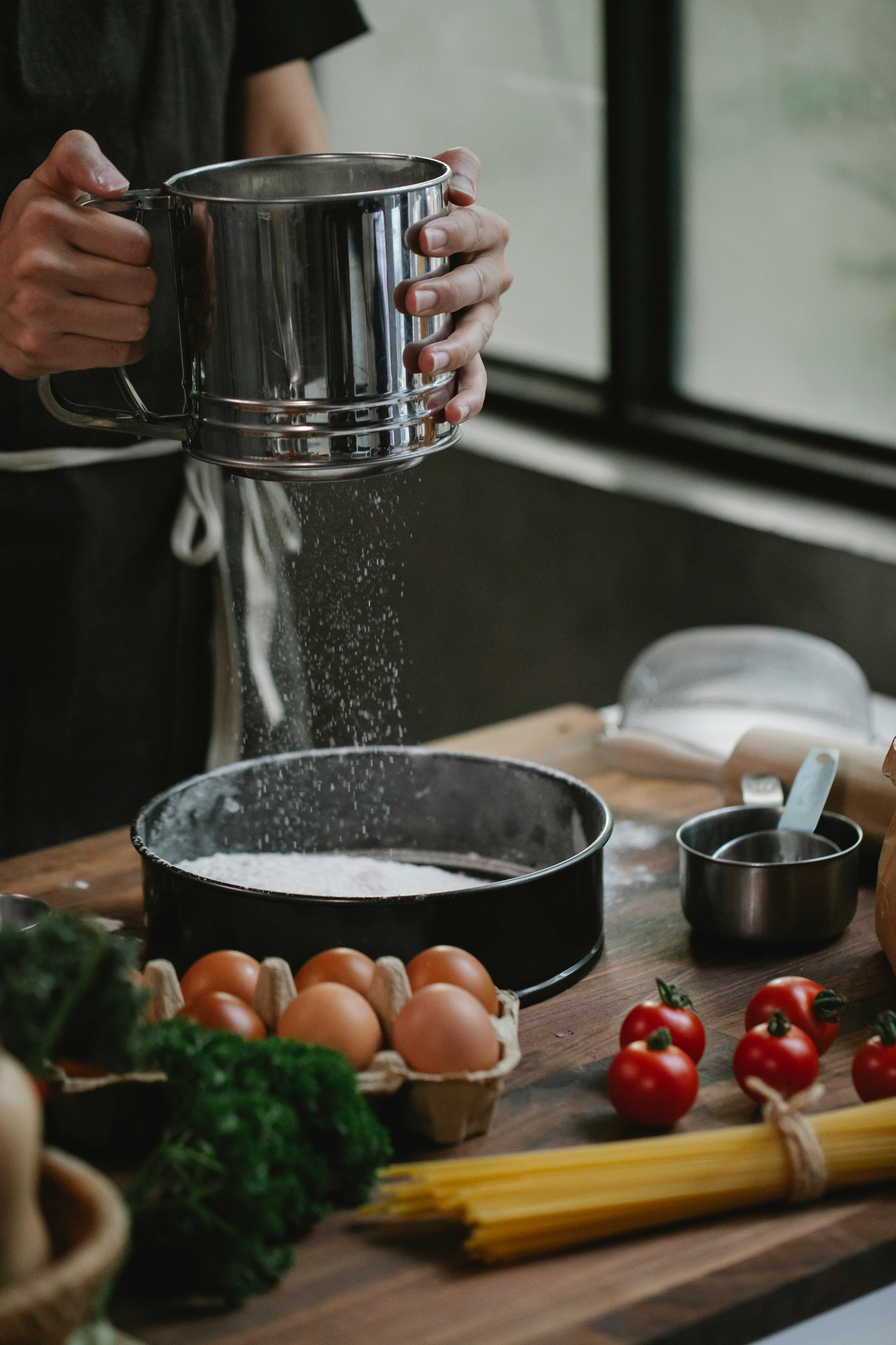 Anonymous chef cooking pasta on table near ingredients · Free Stock Photo