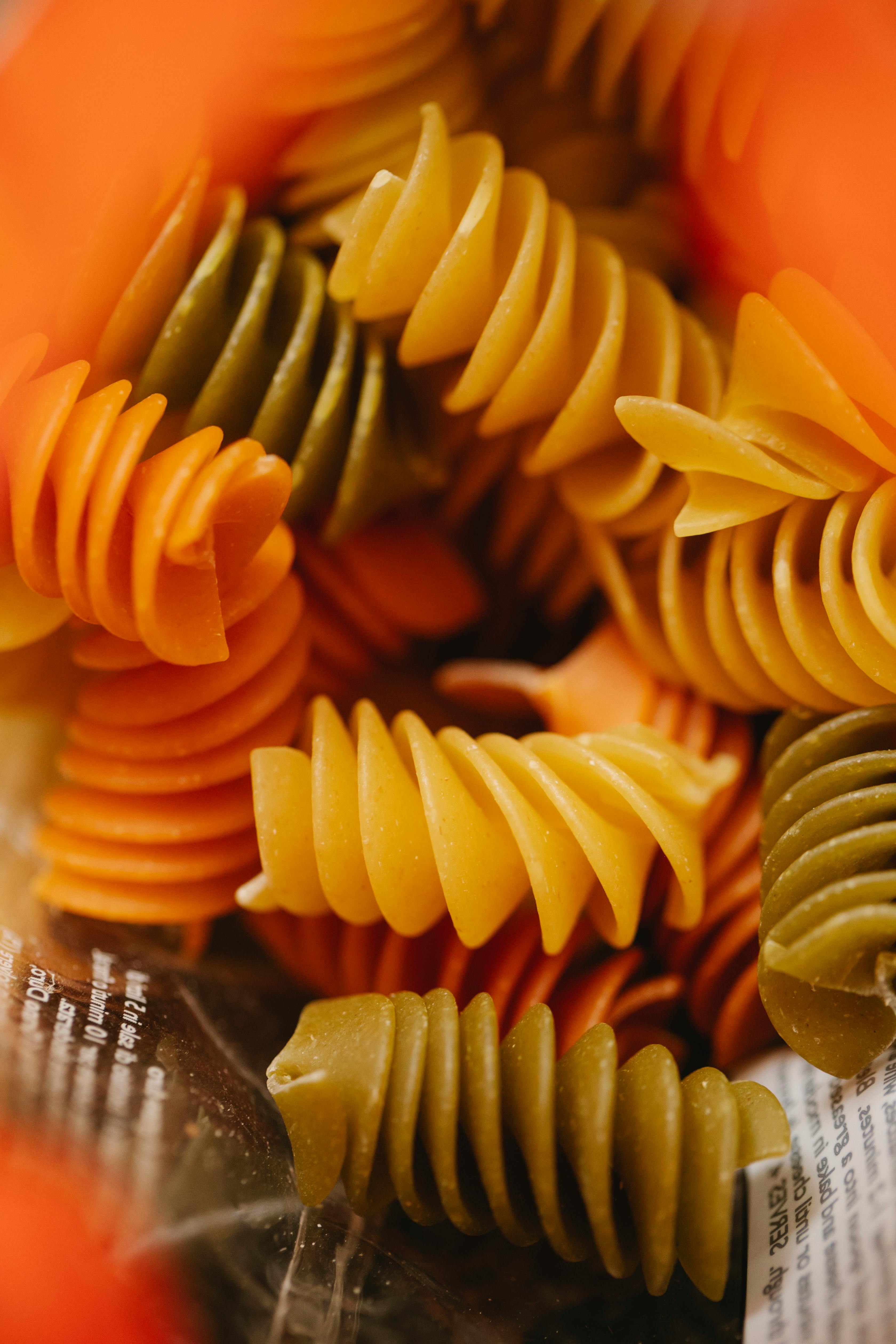 Raw colorful rotini pasta in container · Free Stock Photo