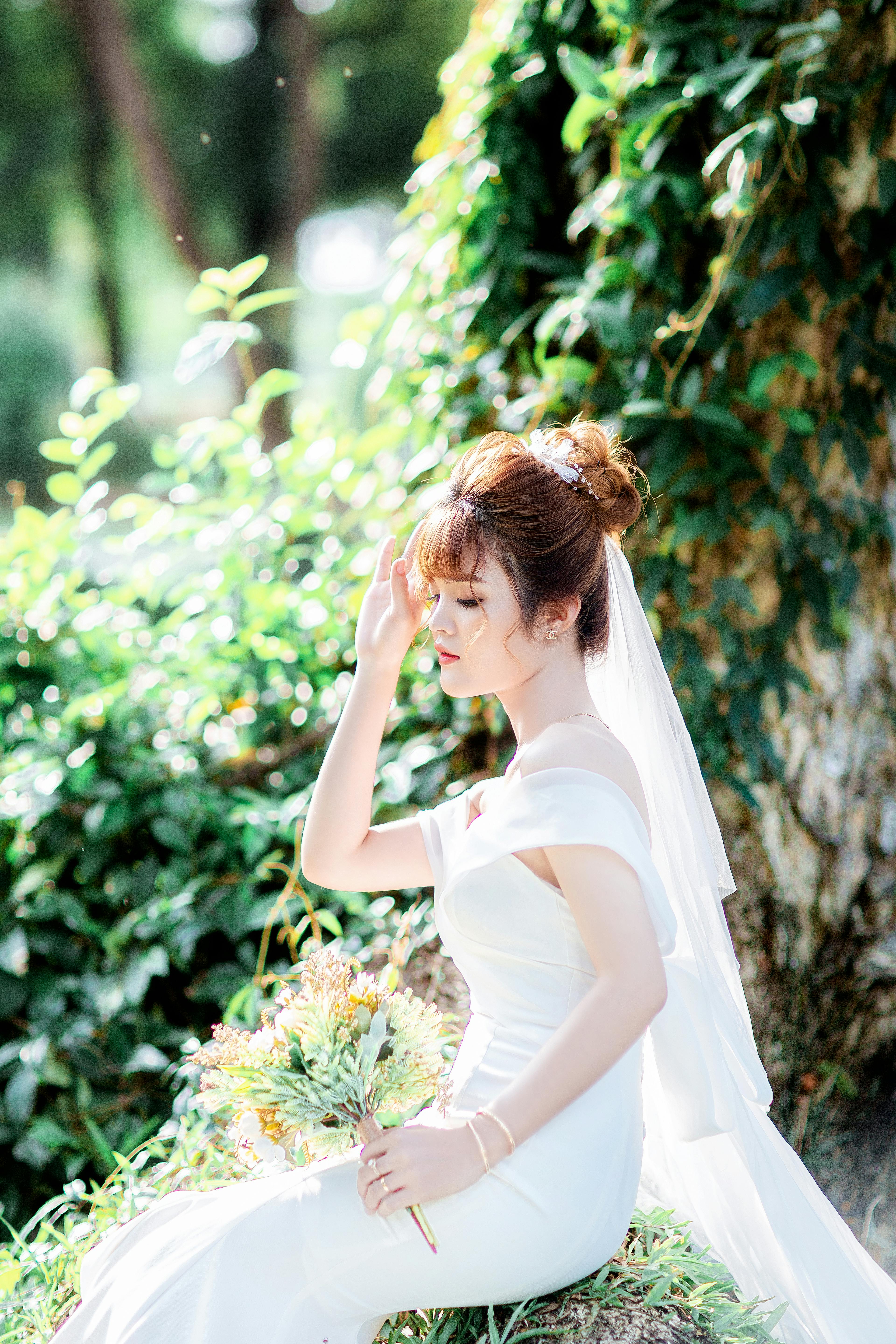 Beautiful Bride Holding Flowers and Posing for Photoshoot · Free Stock ...
