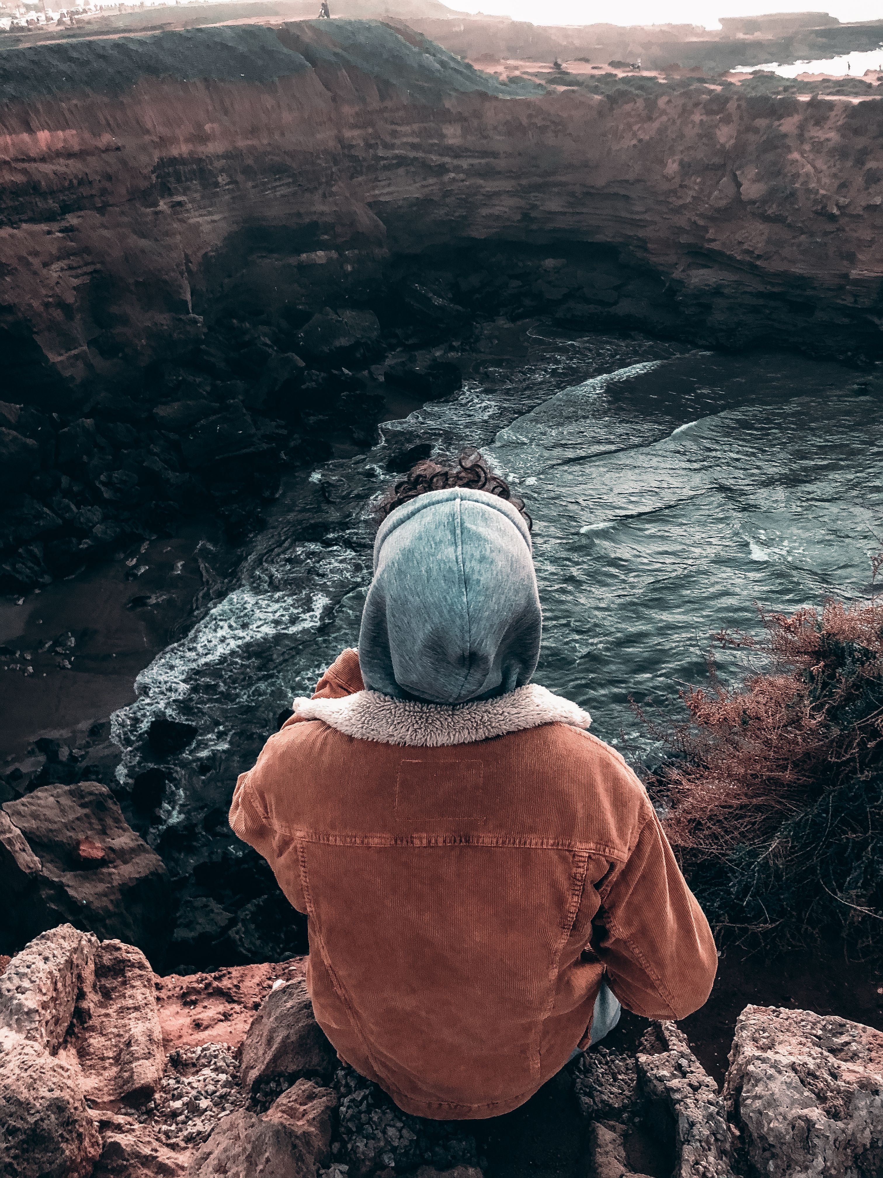 Person Sitting on Top of Cliff · Free Stock Photo