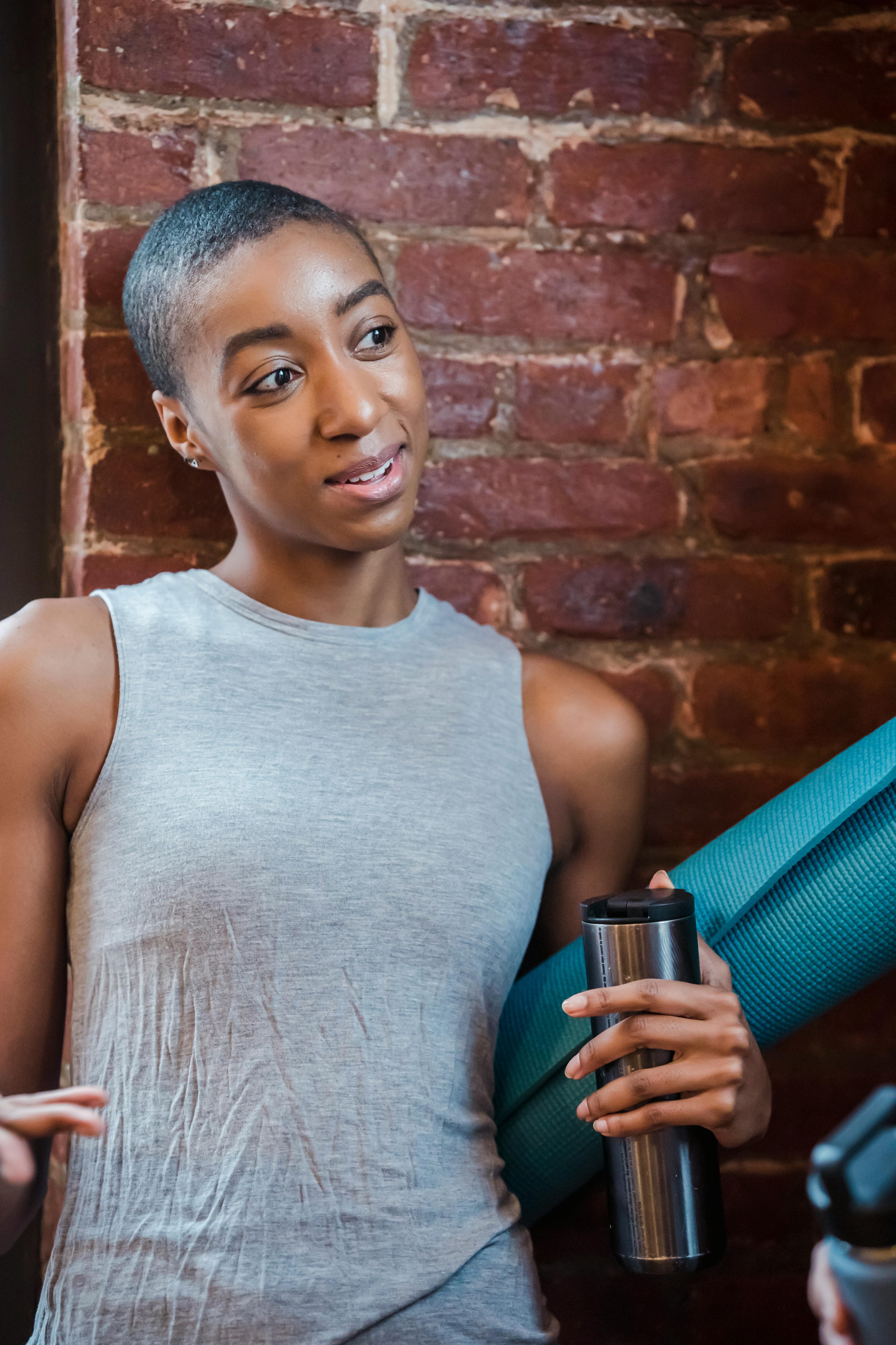 Fit smiling sportswoman waiting at gym reception desk · Free Stock Photo