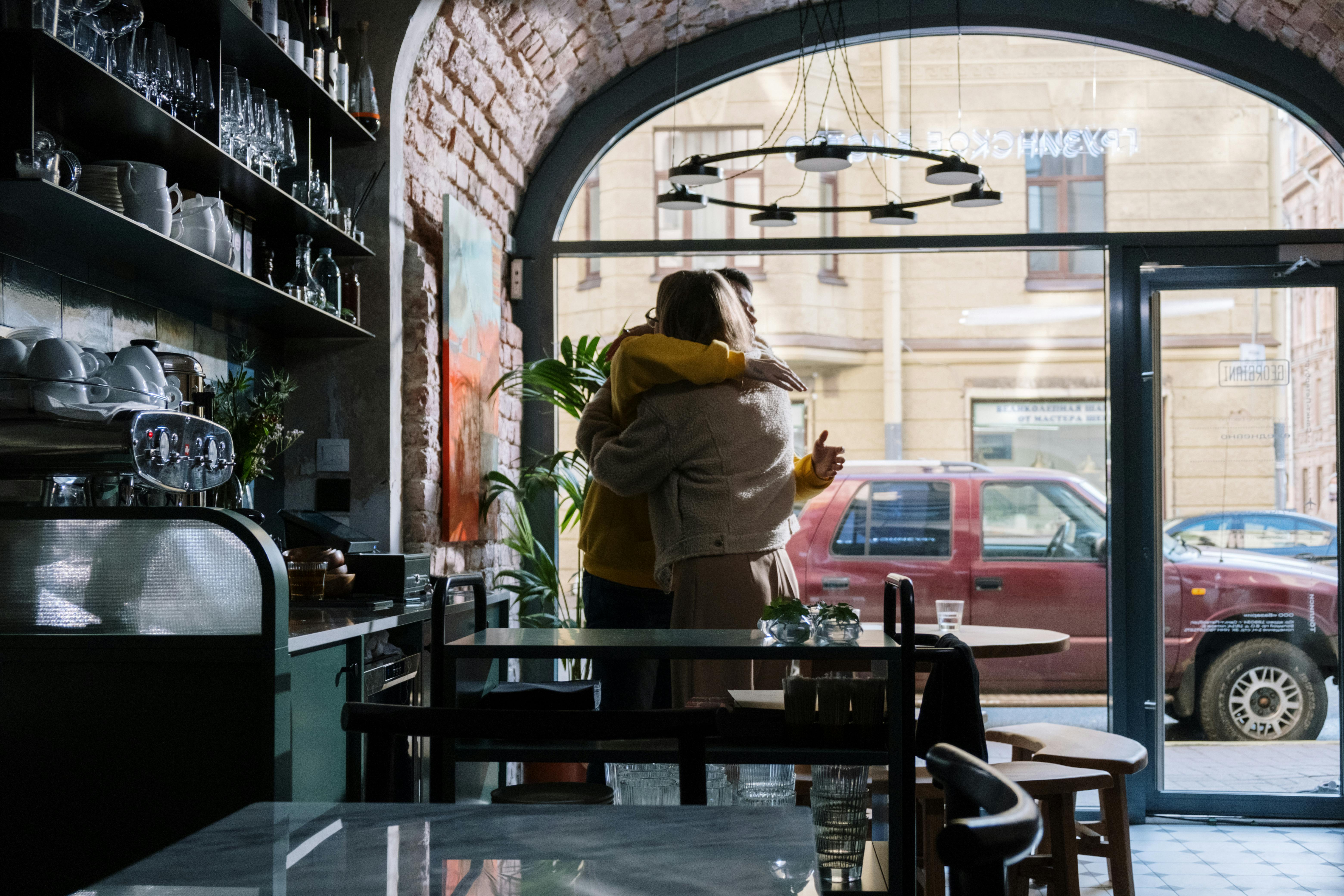 Man and Woman Hugging Inside a Restaurant · Free Stock Photo