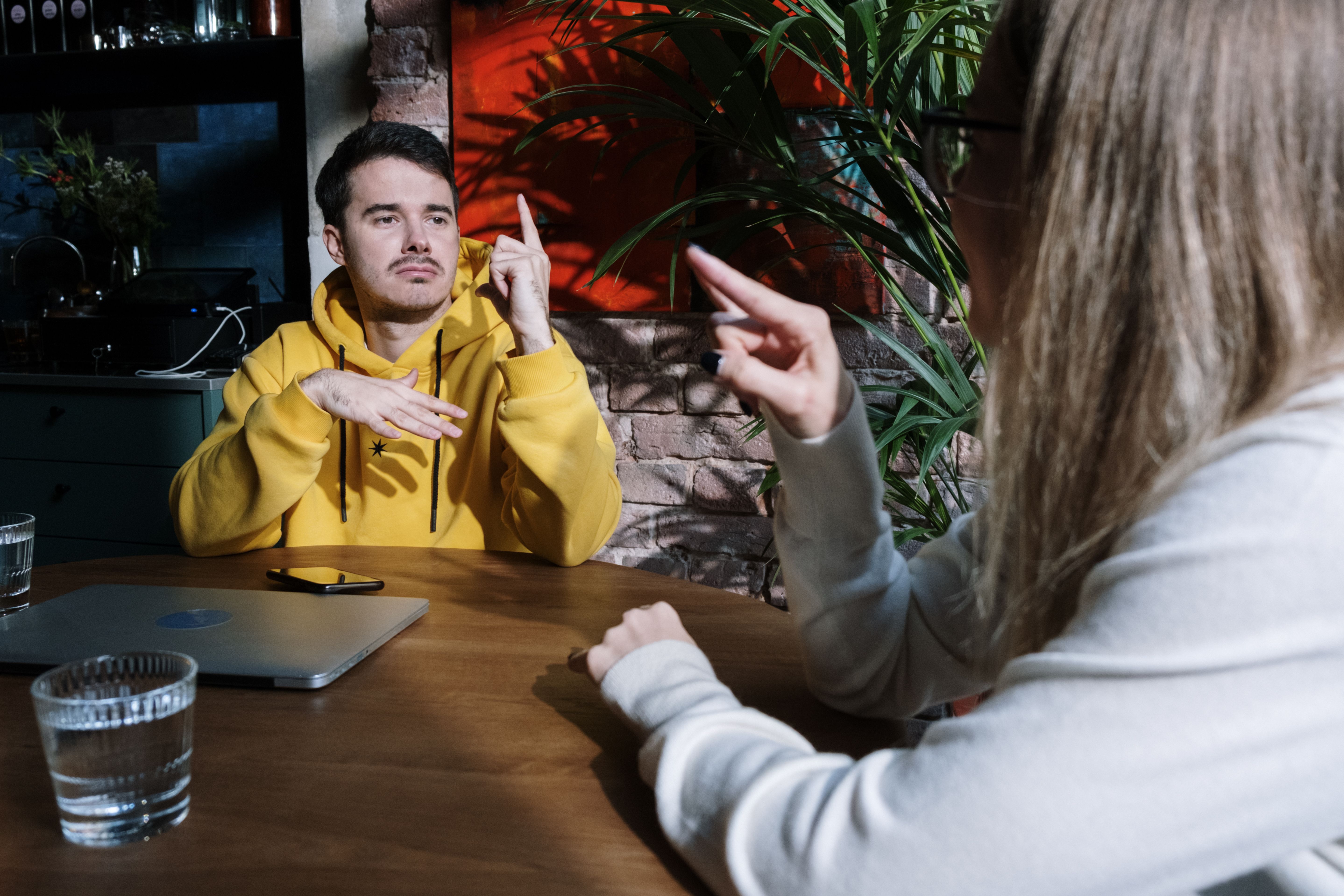 A Man and a Woman Using Hand Gesture in Communicating · Free Stock Photo