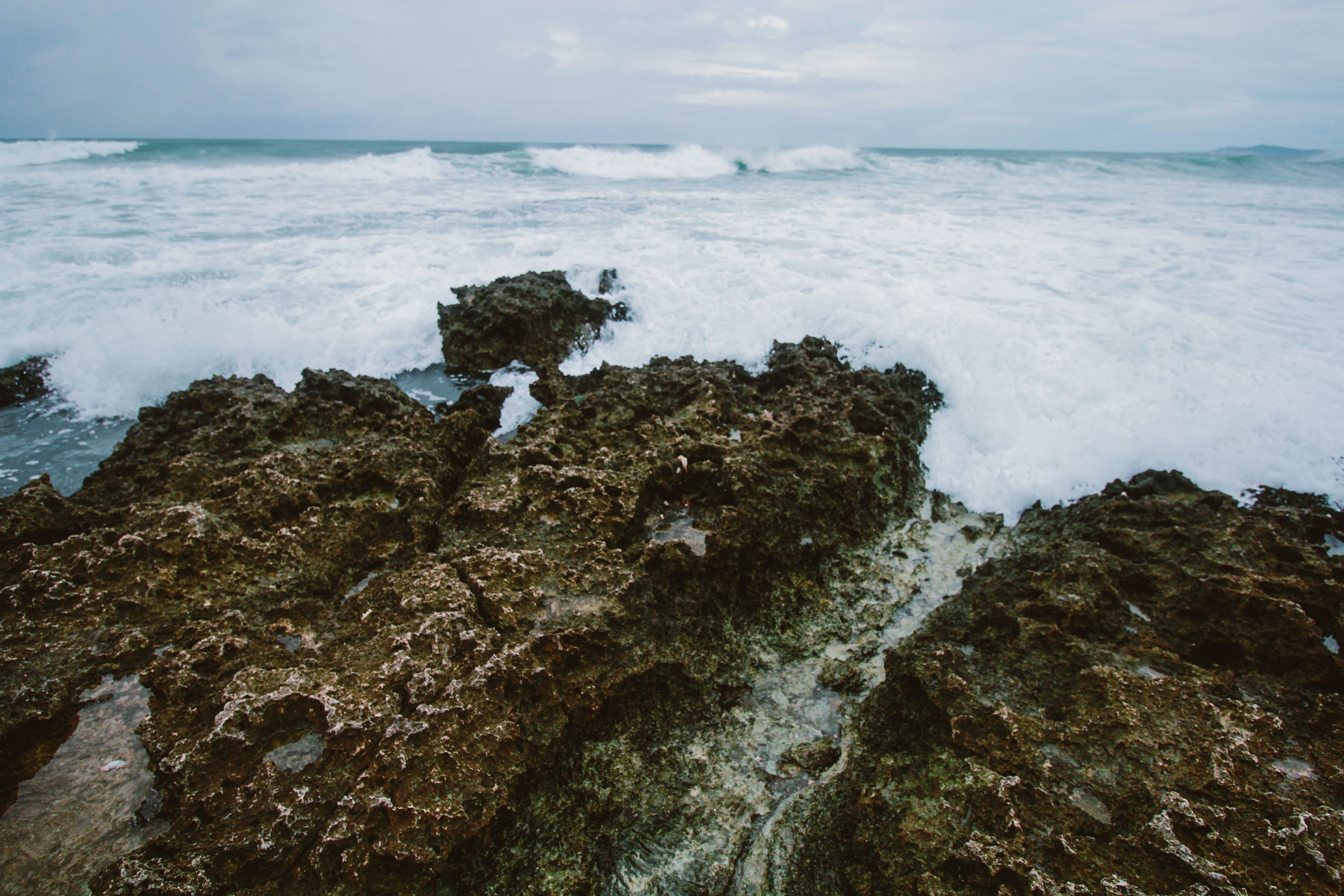 Woman Sitting on Rock Near Body of Water · Free Stock Photo