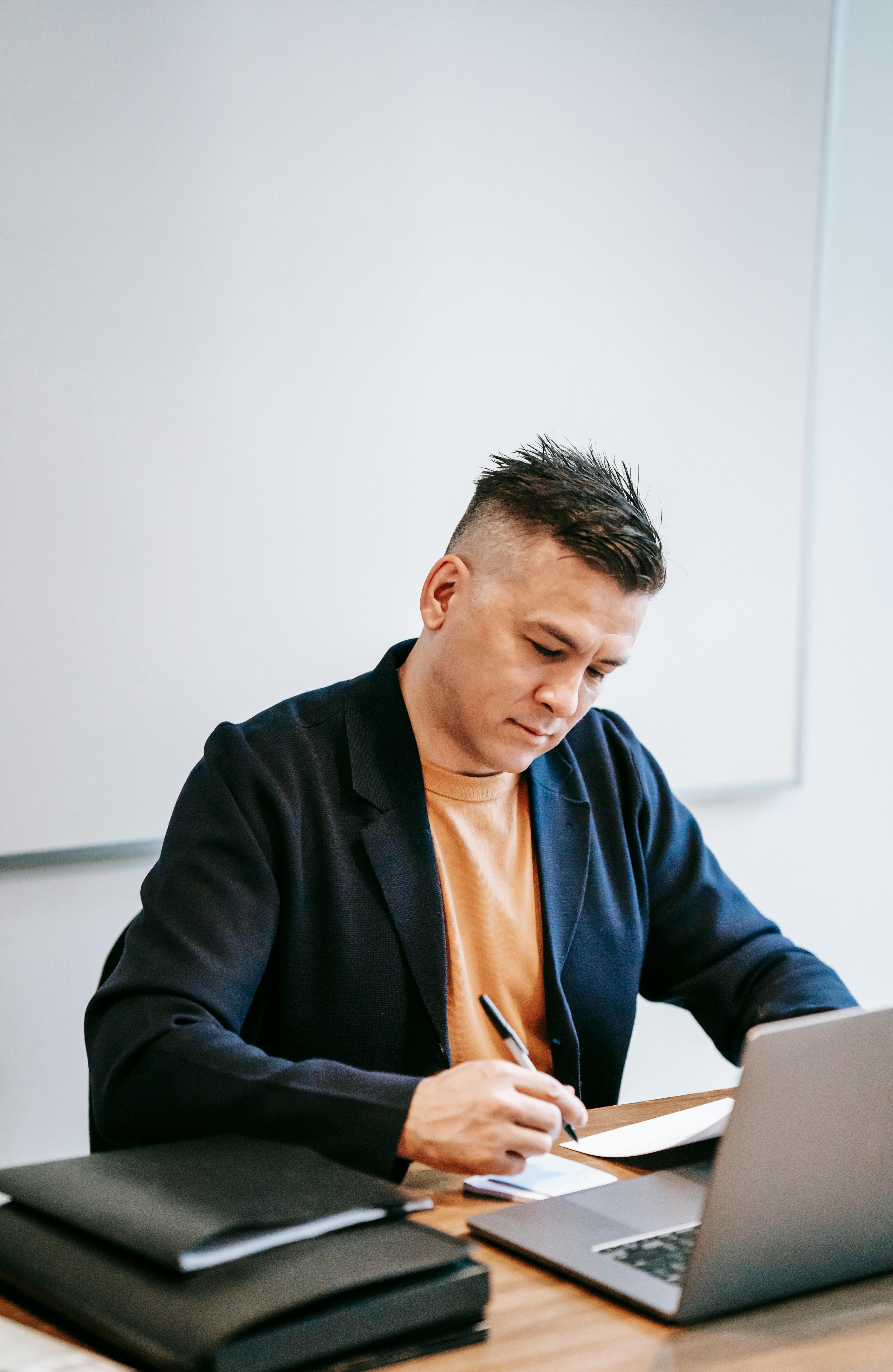 Photo Of Man Writing On Paper · Free Stock Photo