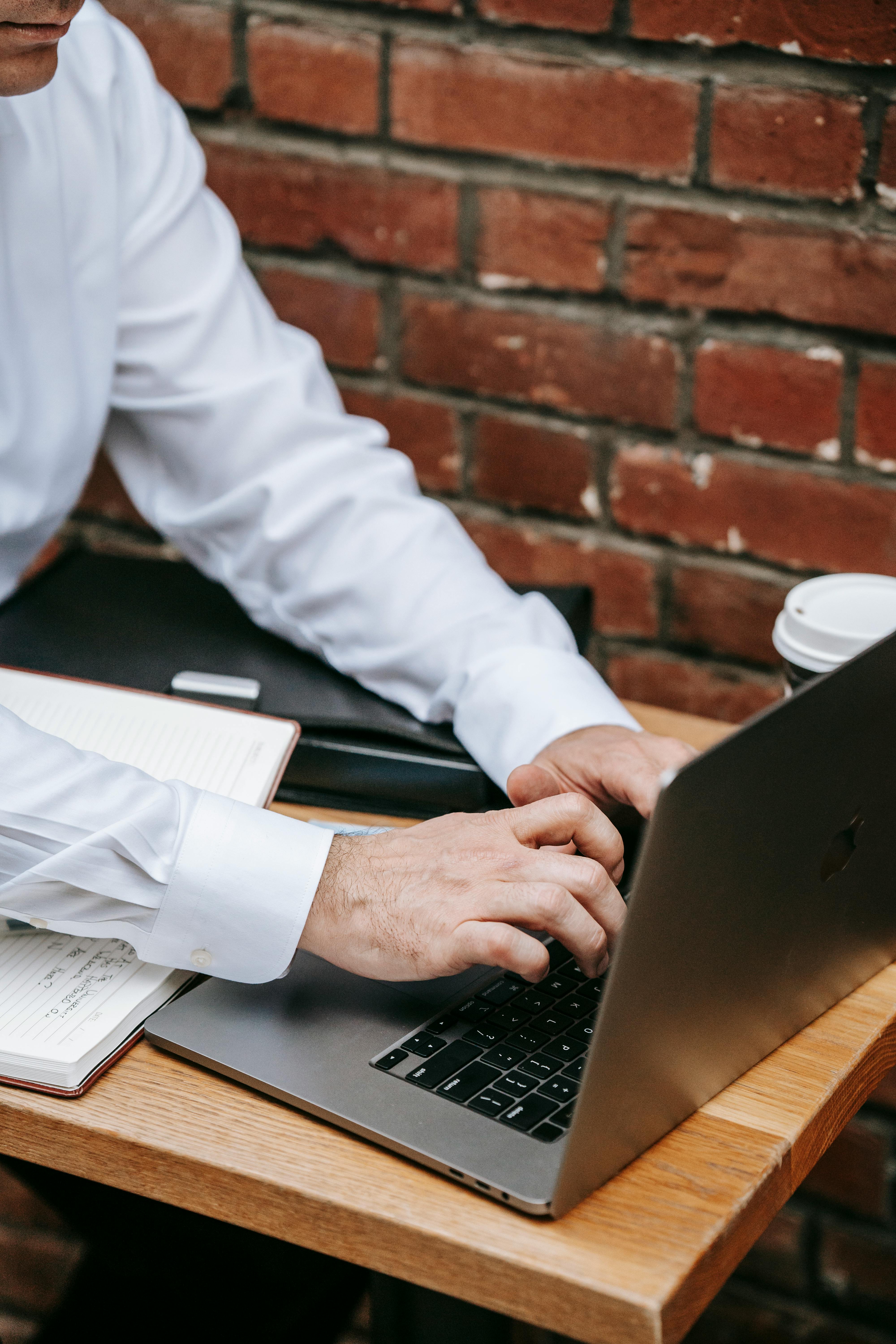 Photo Of Person Working On Top Of Wooden Table · Free Stock Photo
