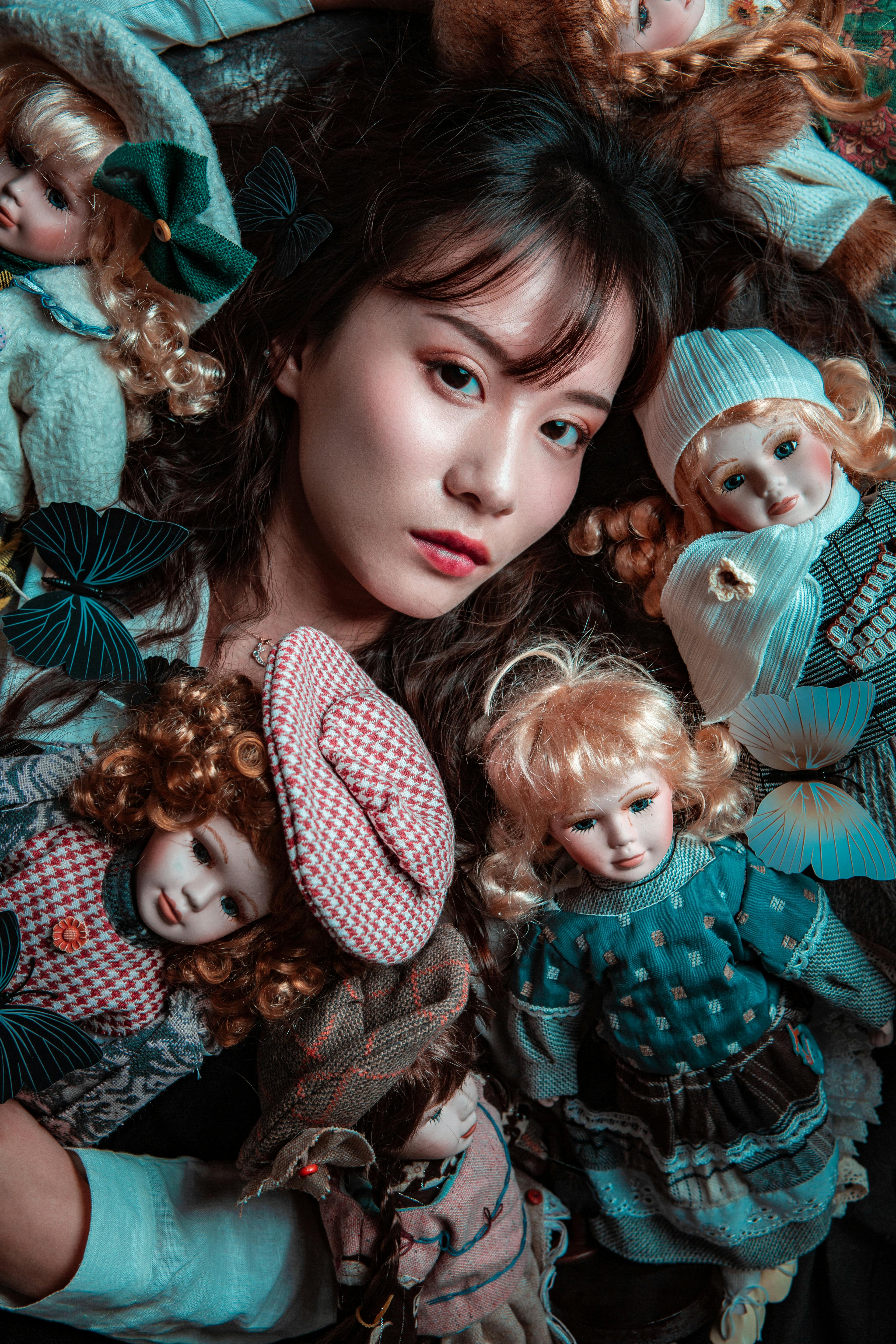 A Woman Lying Down with Dolls · Free Stock Photo