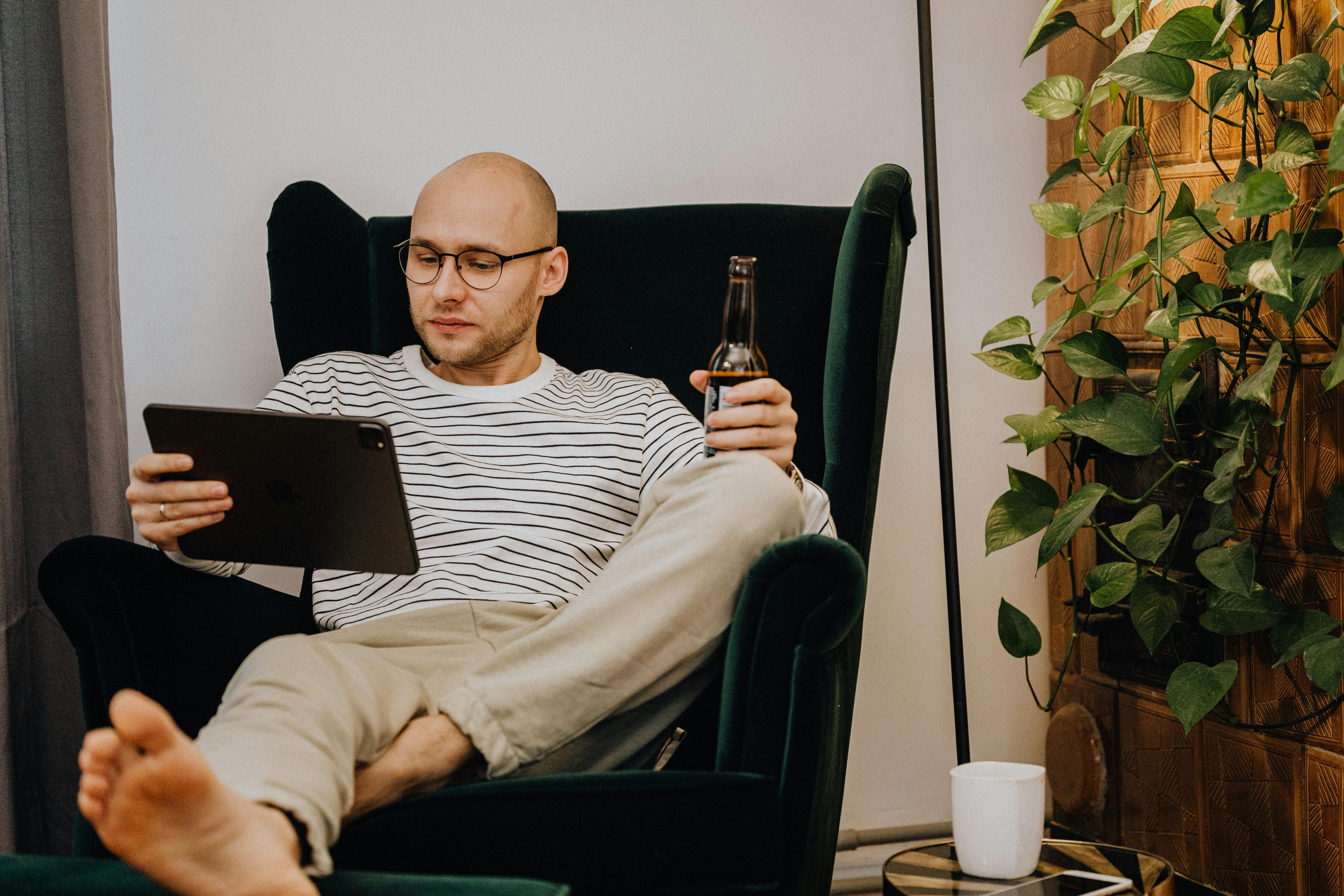 Man Relaxing in Chair with Tablet Drinking Beer · Free Stock Photo