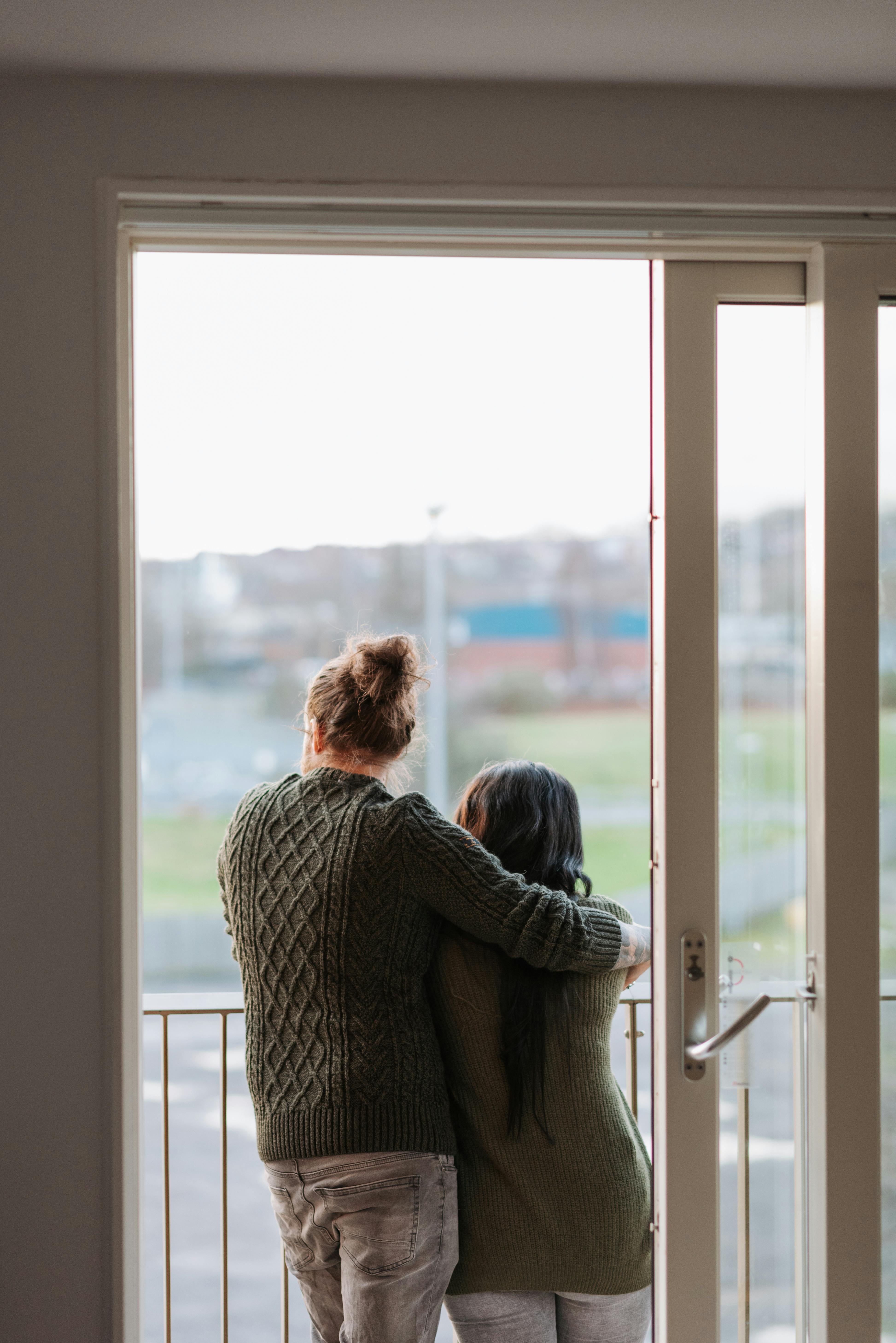 Faceless couple embracing on balcony against city · Free Stock Photo
