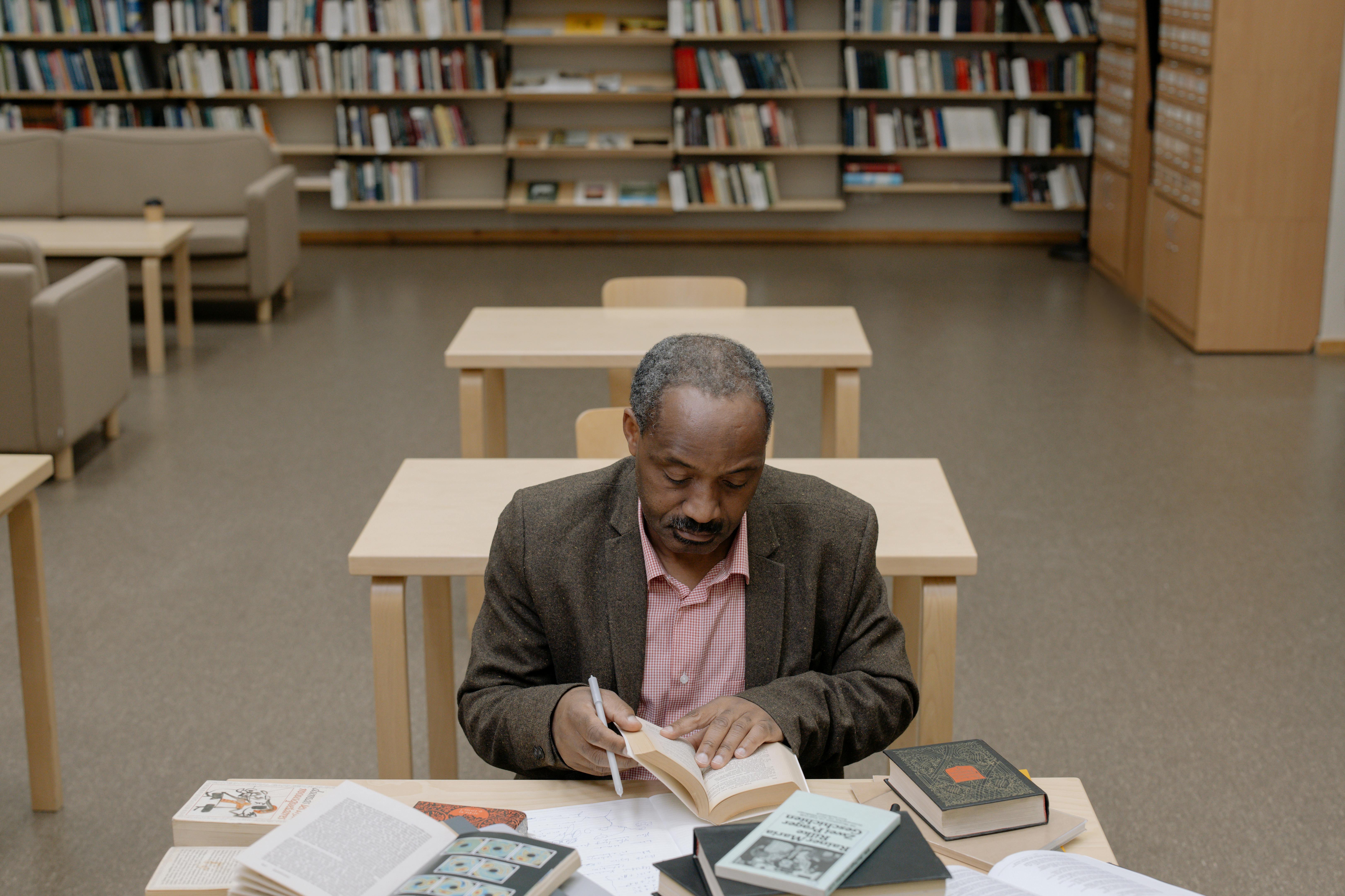 Man in White Dress Shirt Wearing Black Framed Eyeglasses Reading Book ...