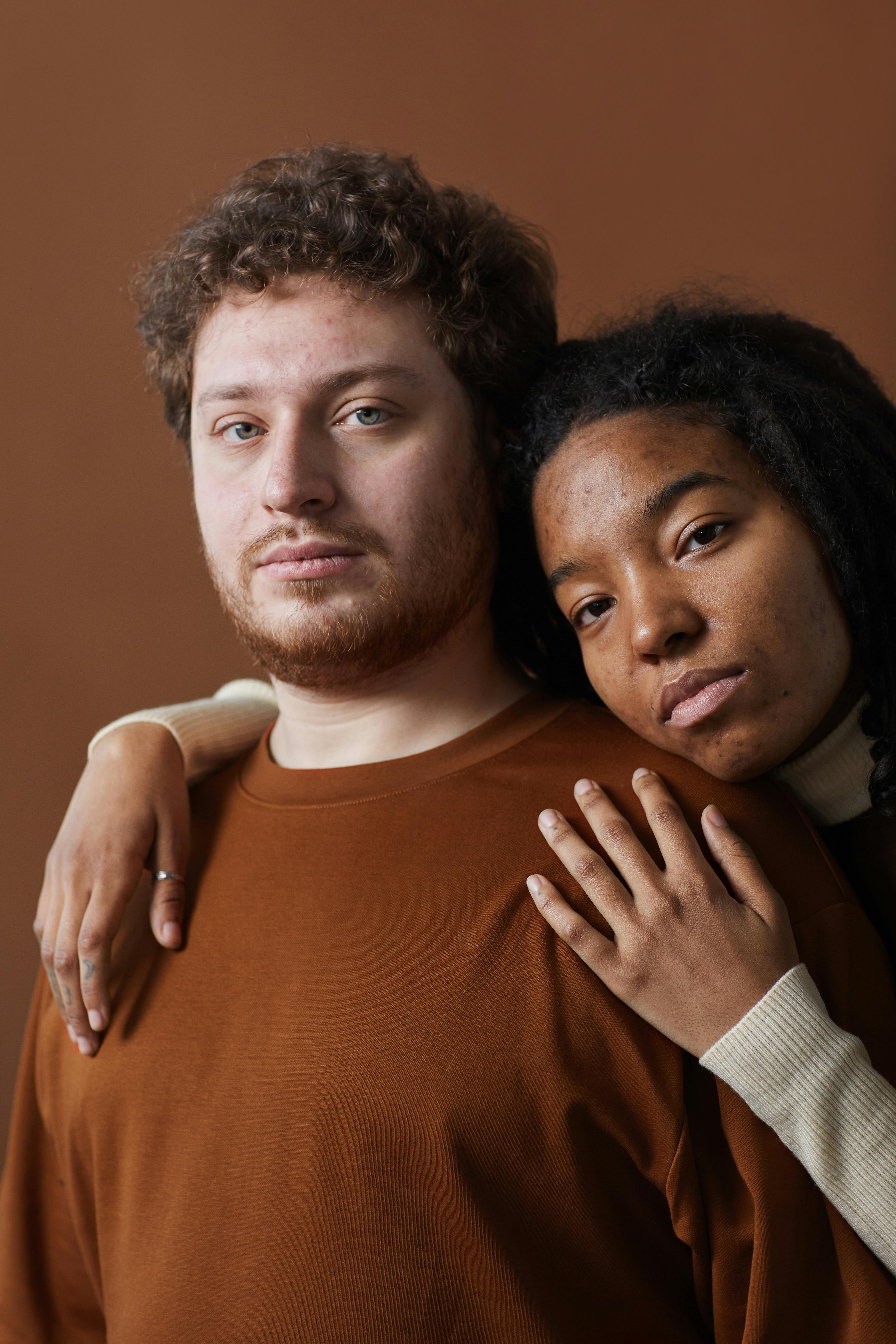 Woman Wraps Her Arms Around a Man's Shoulder · Free Stock Photo