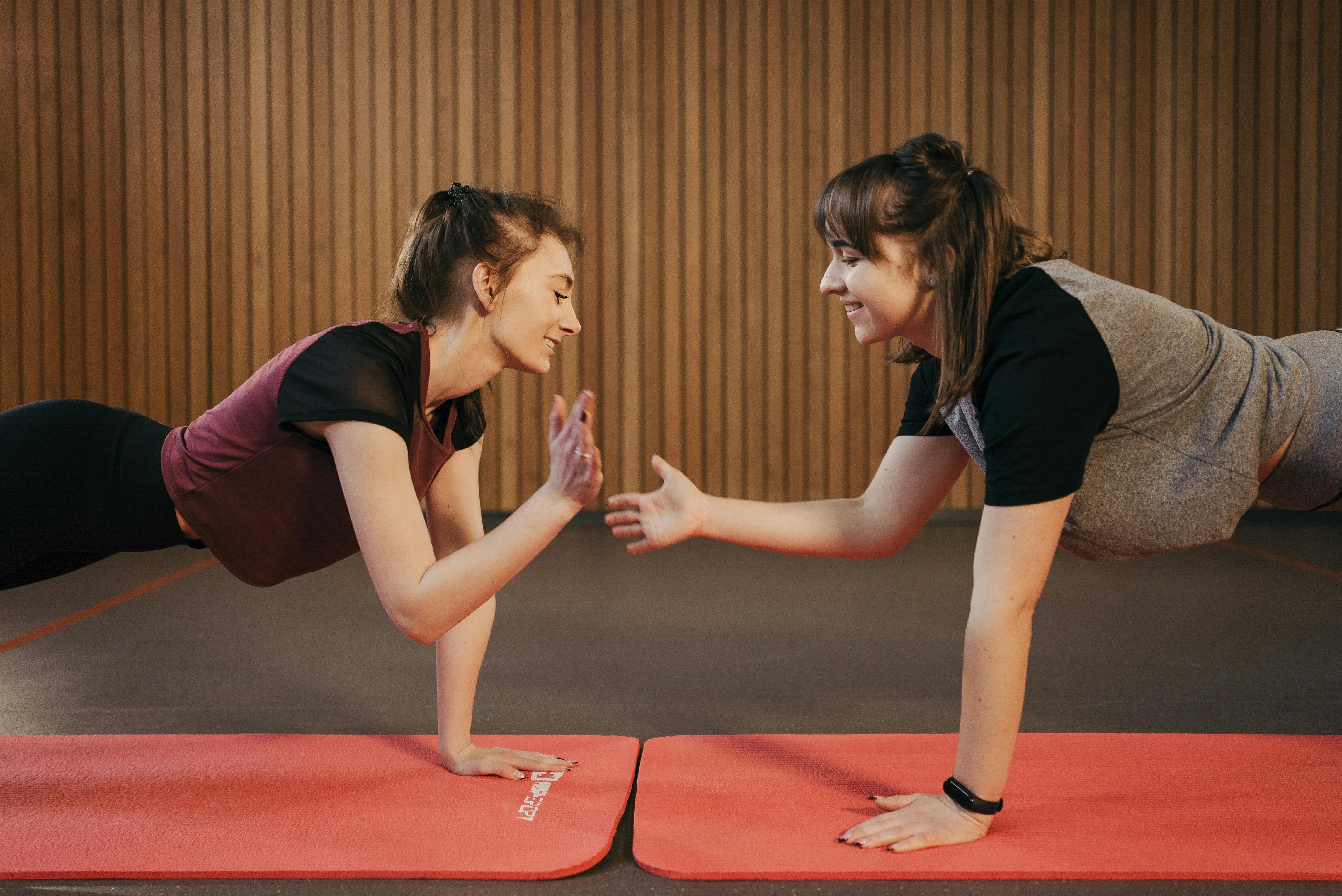 A Pair of Women Doing the Planks on Pink Mats · Free Stock Photo
