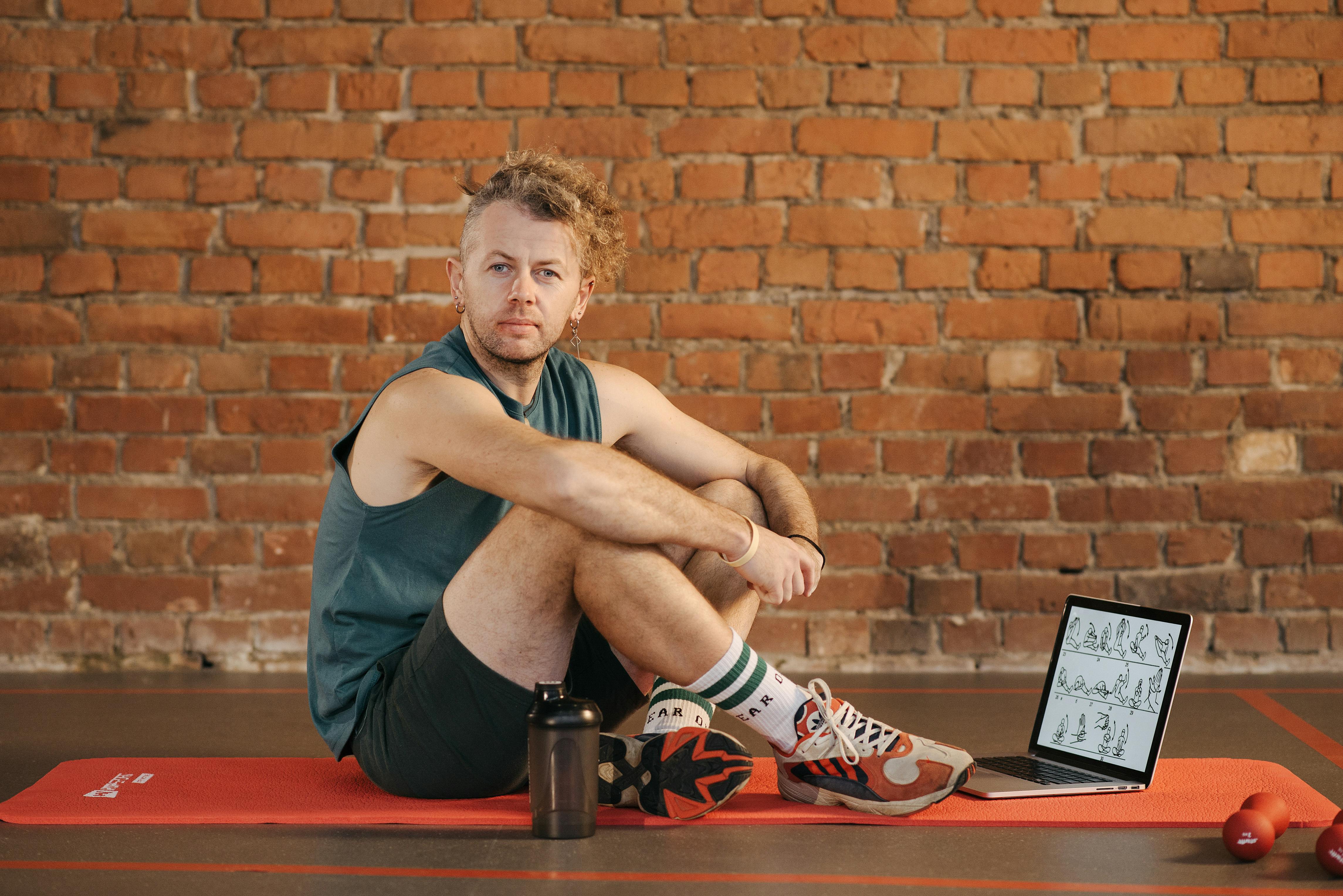 Man Sitting on an Exercise Mat · Free Stock Photo