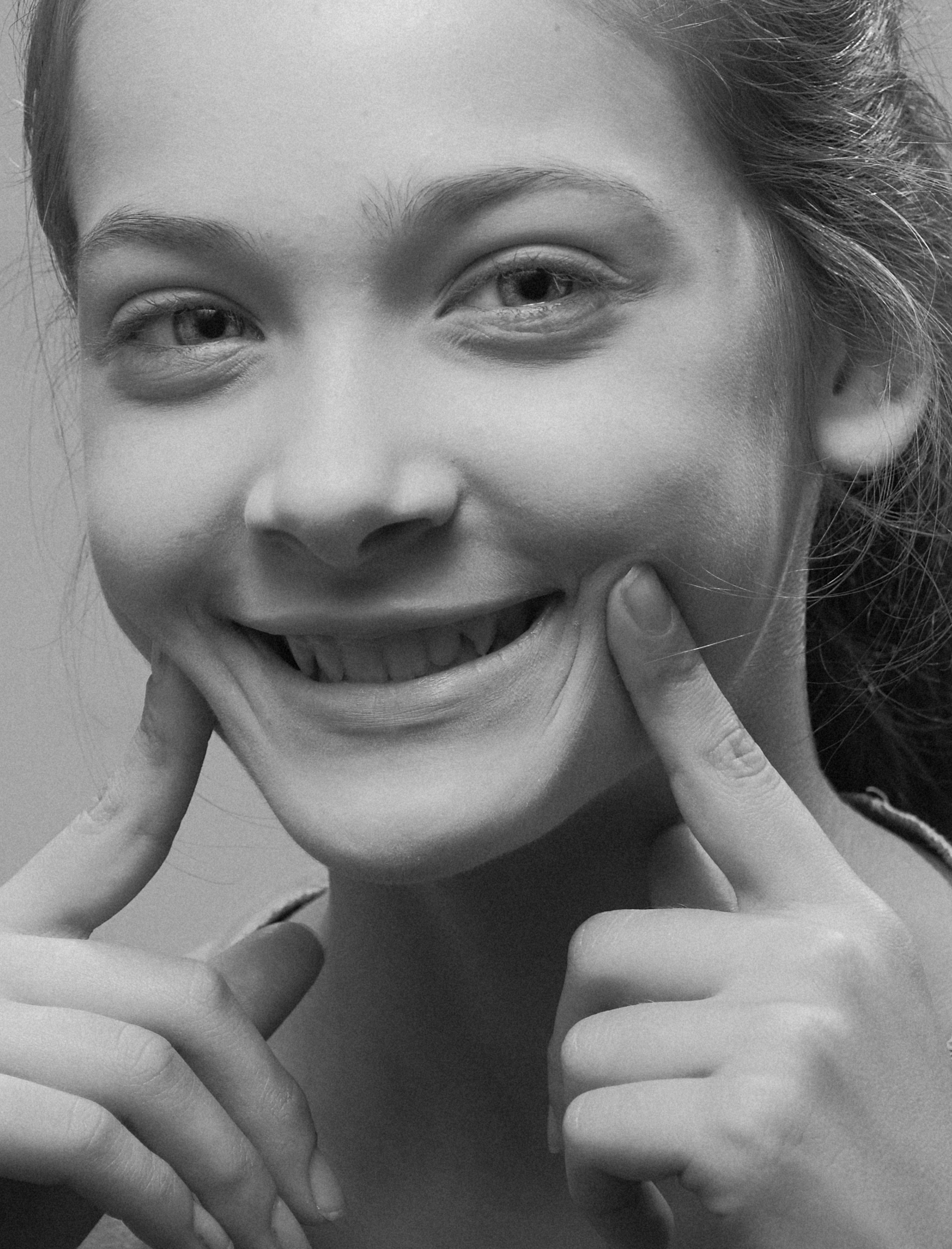 A Girl Smiling With Fingers on Her Face · Free Stock Photo