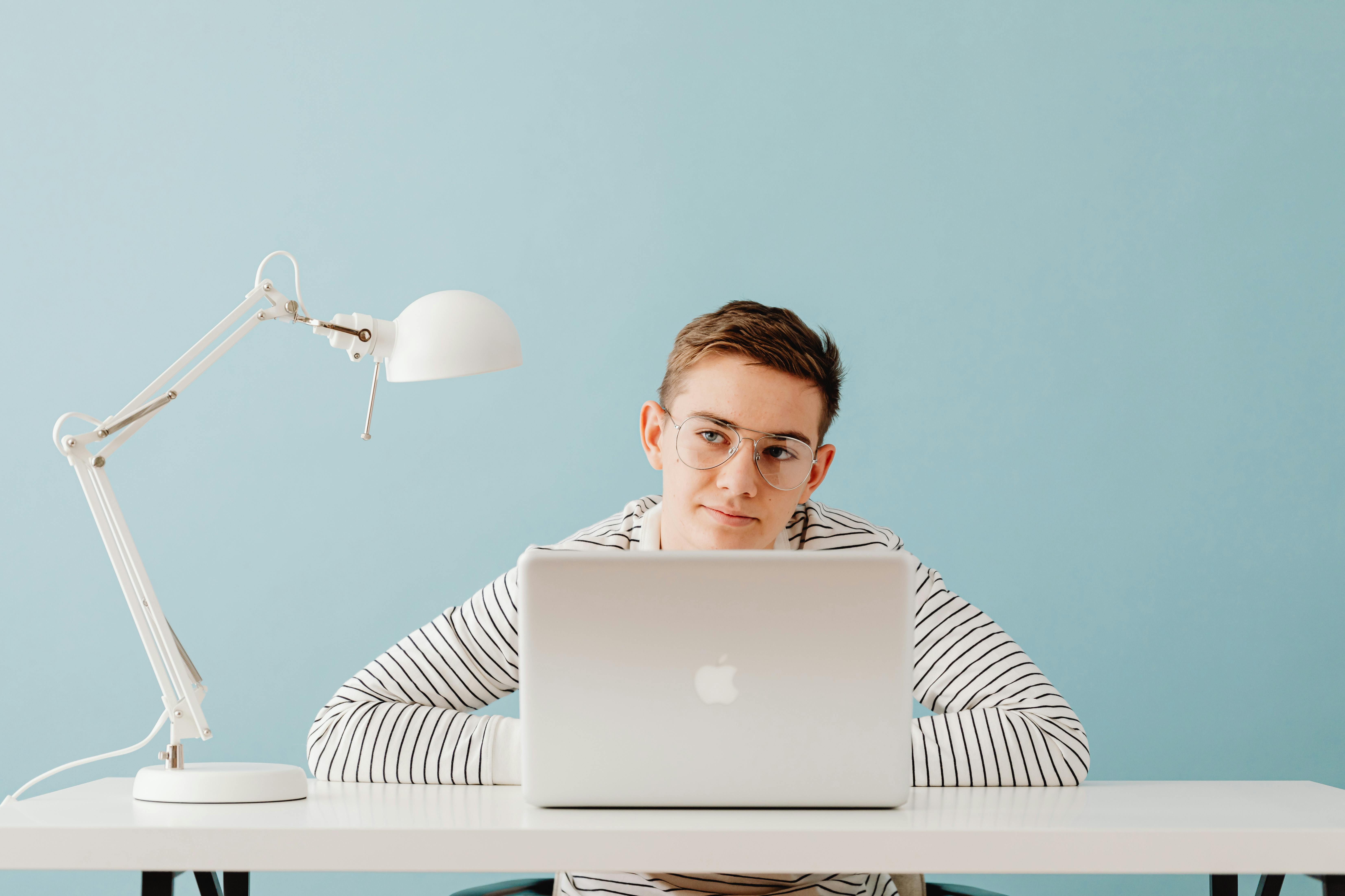Man Sitting by Table with Laptop · Free Stock Photo