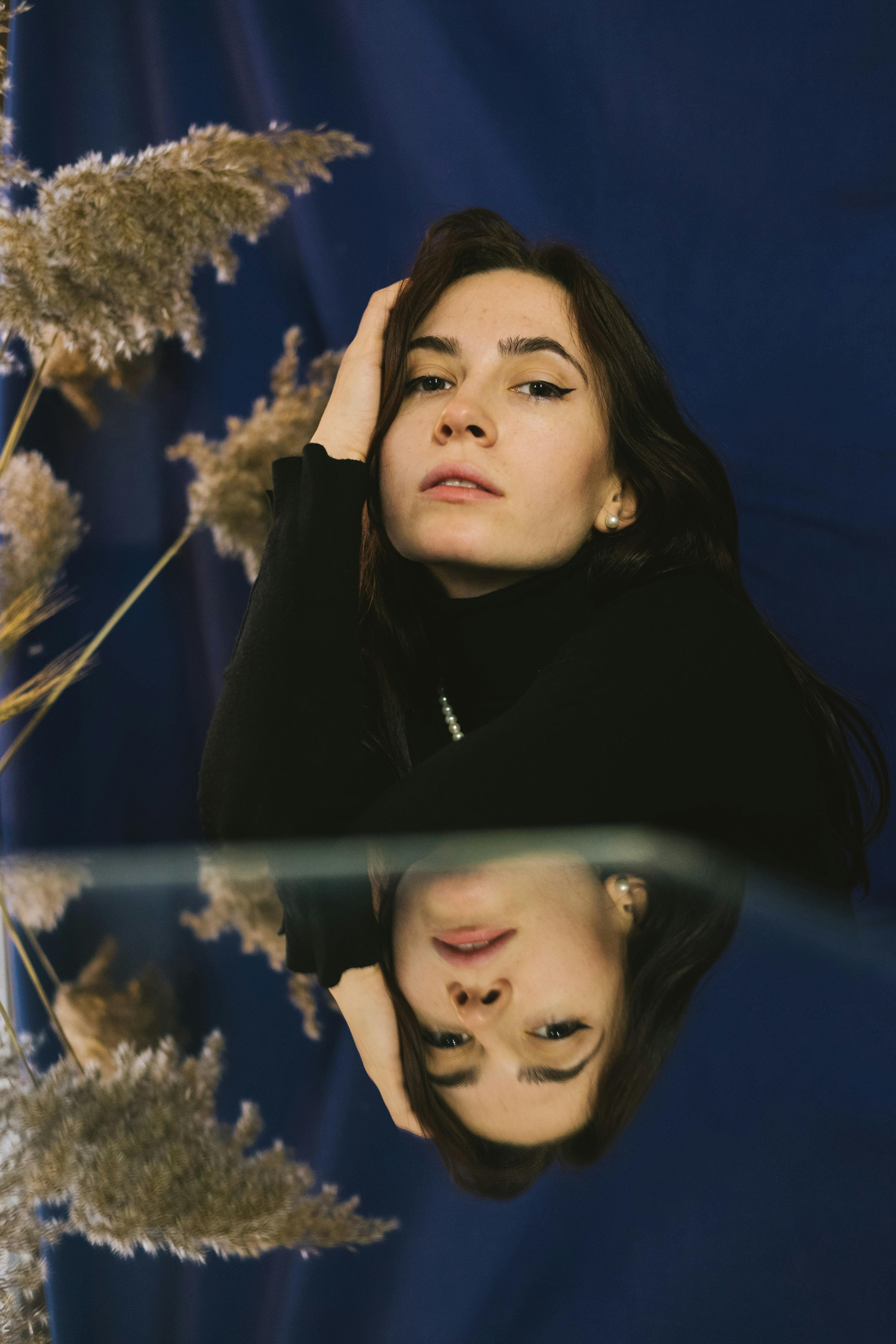 Woman touching shoulder while standing near mirror · Free Stock Photo