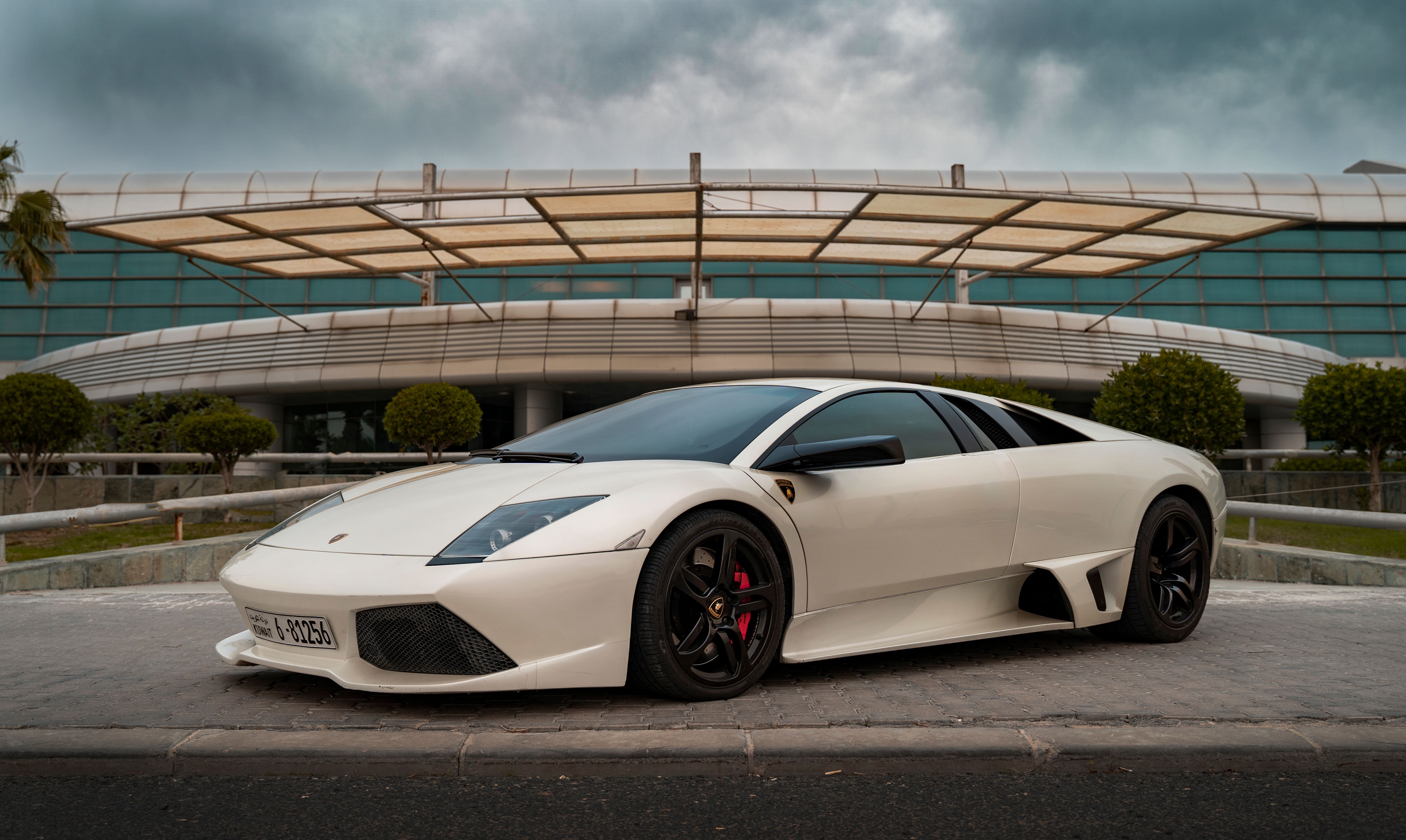 A White Lamborghini Parked in Front a Building · Free Stock Photo